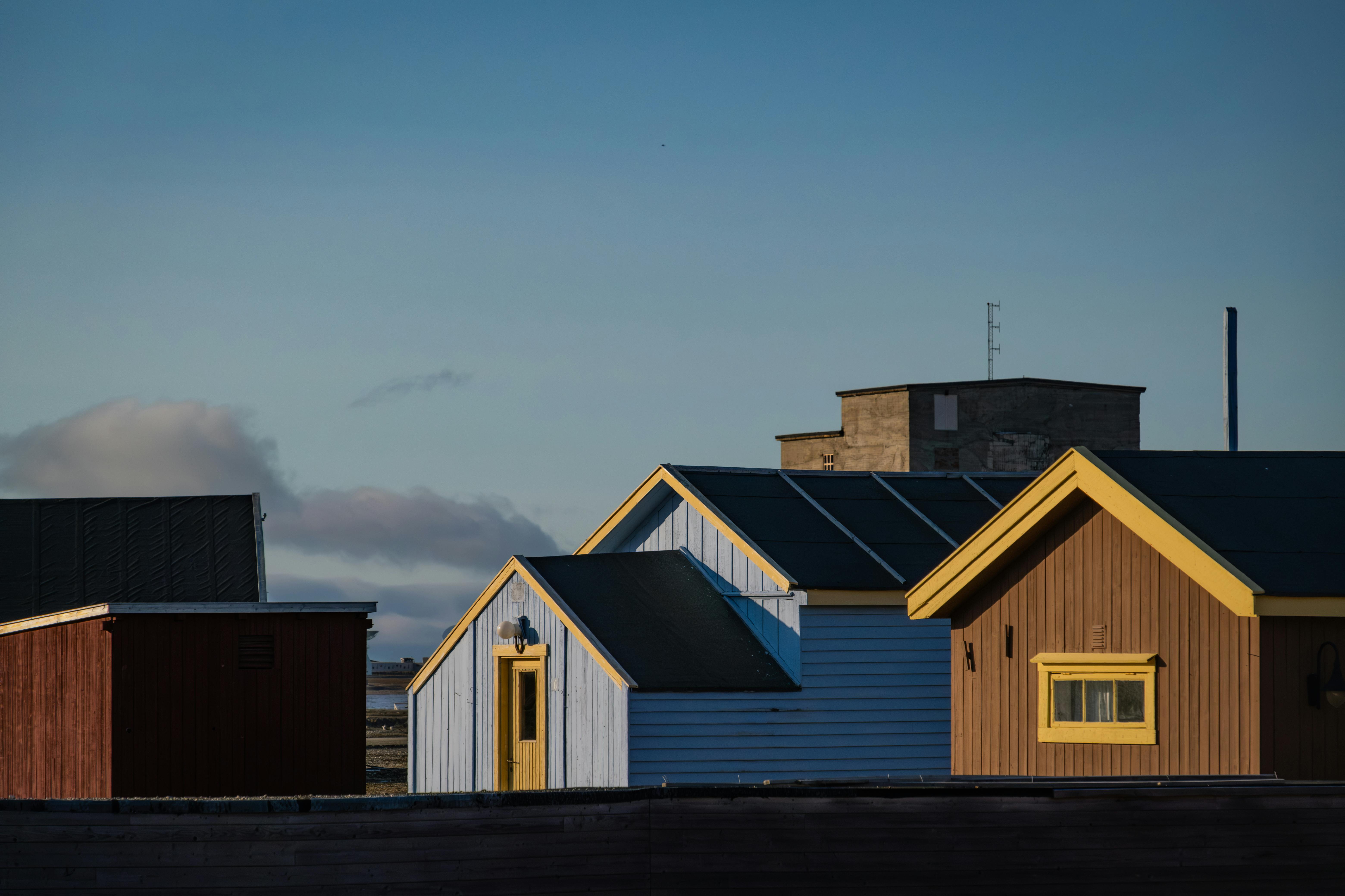 Colorful Coastal Cabins at Sunset · Free Stock Photo