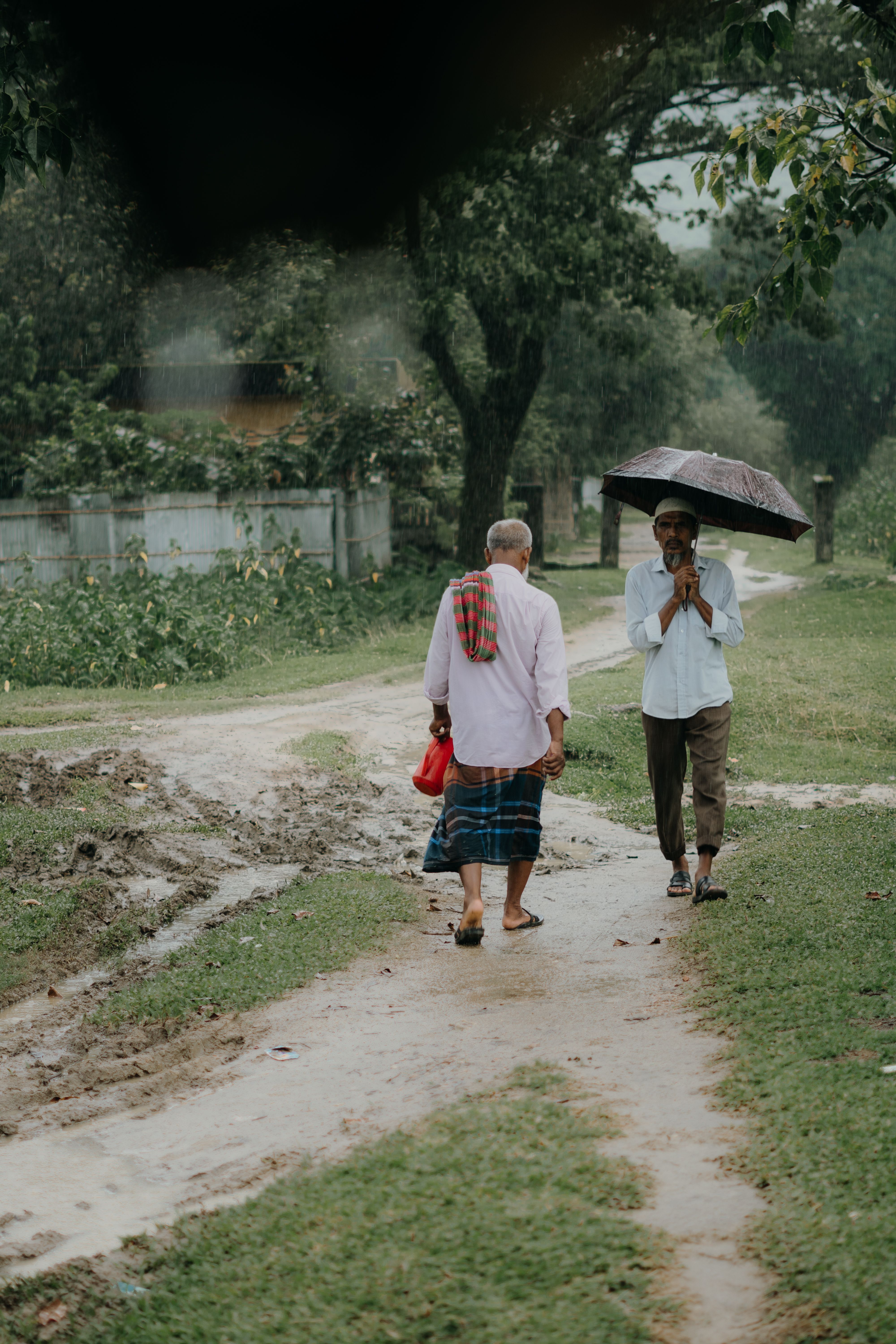 Rural Scene with Two Men Walking in the Rain · Free Stock Photo