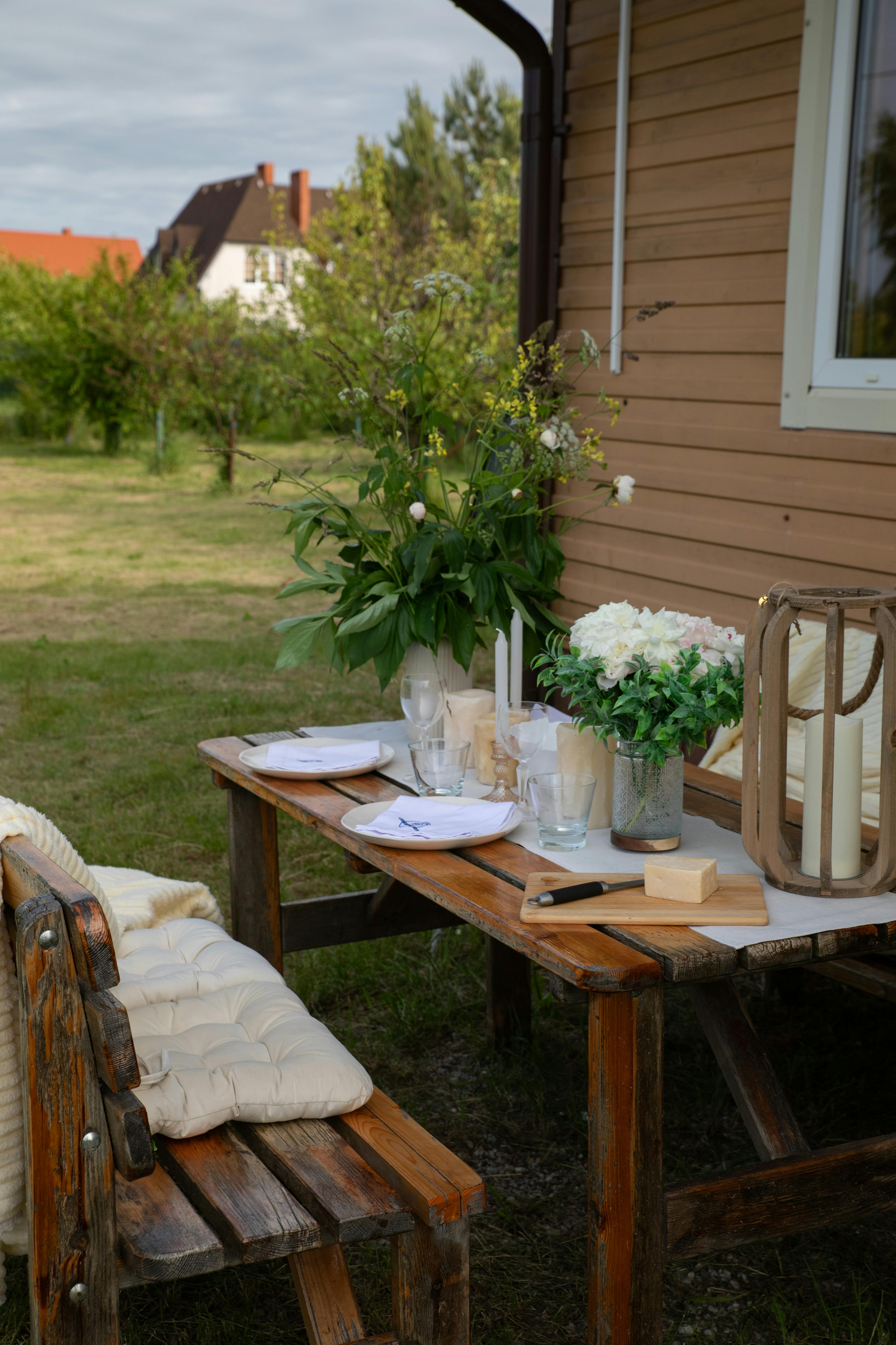 Outdoor Rustic Dining Setup with Flowers · Free Stock Photo