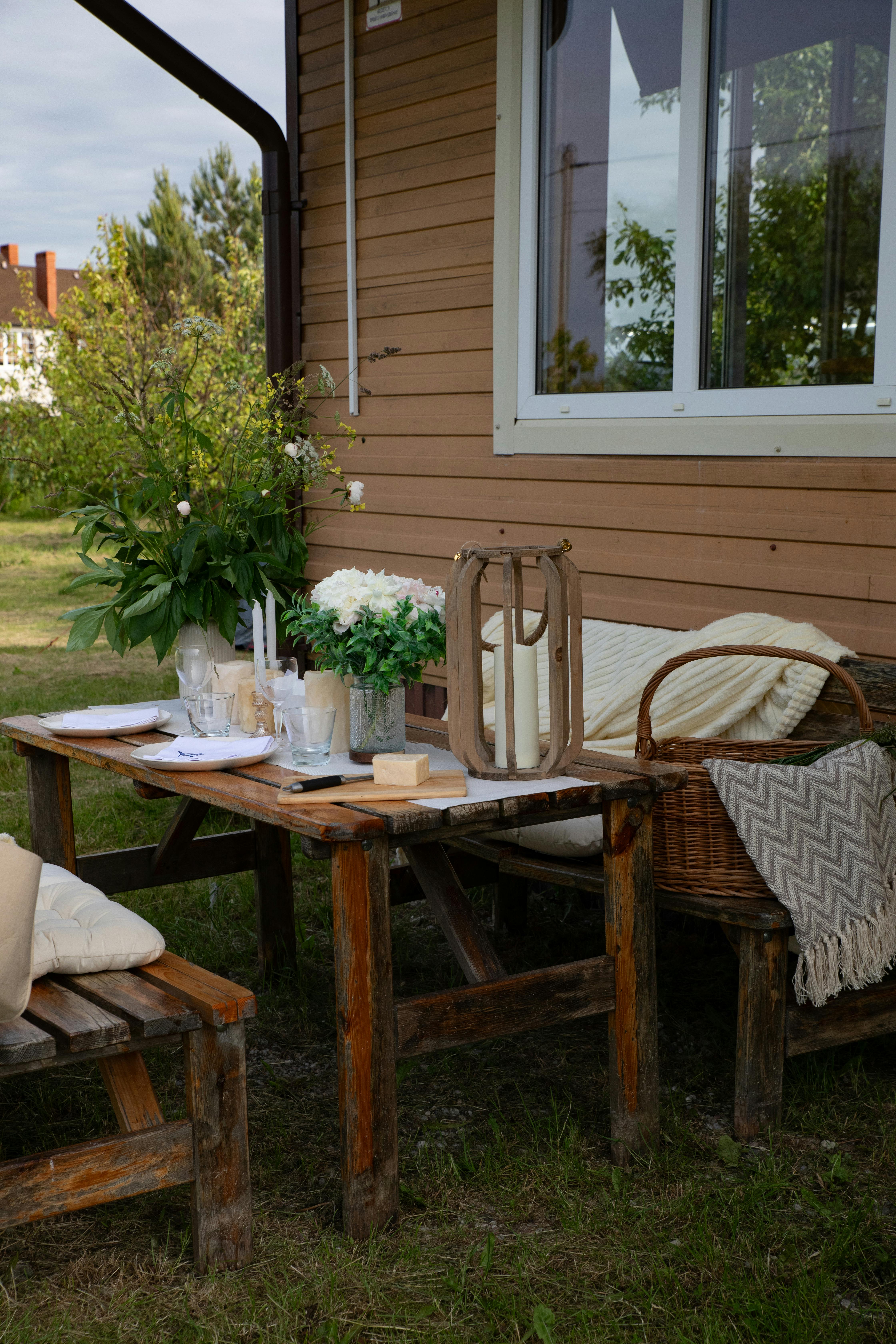 Rustic Outdoor Dining Setup with Flowers and Blanket · Free Stock Photo