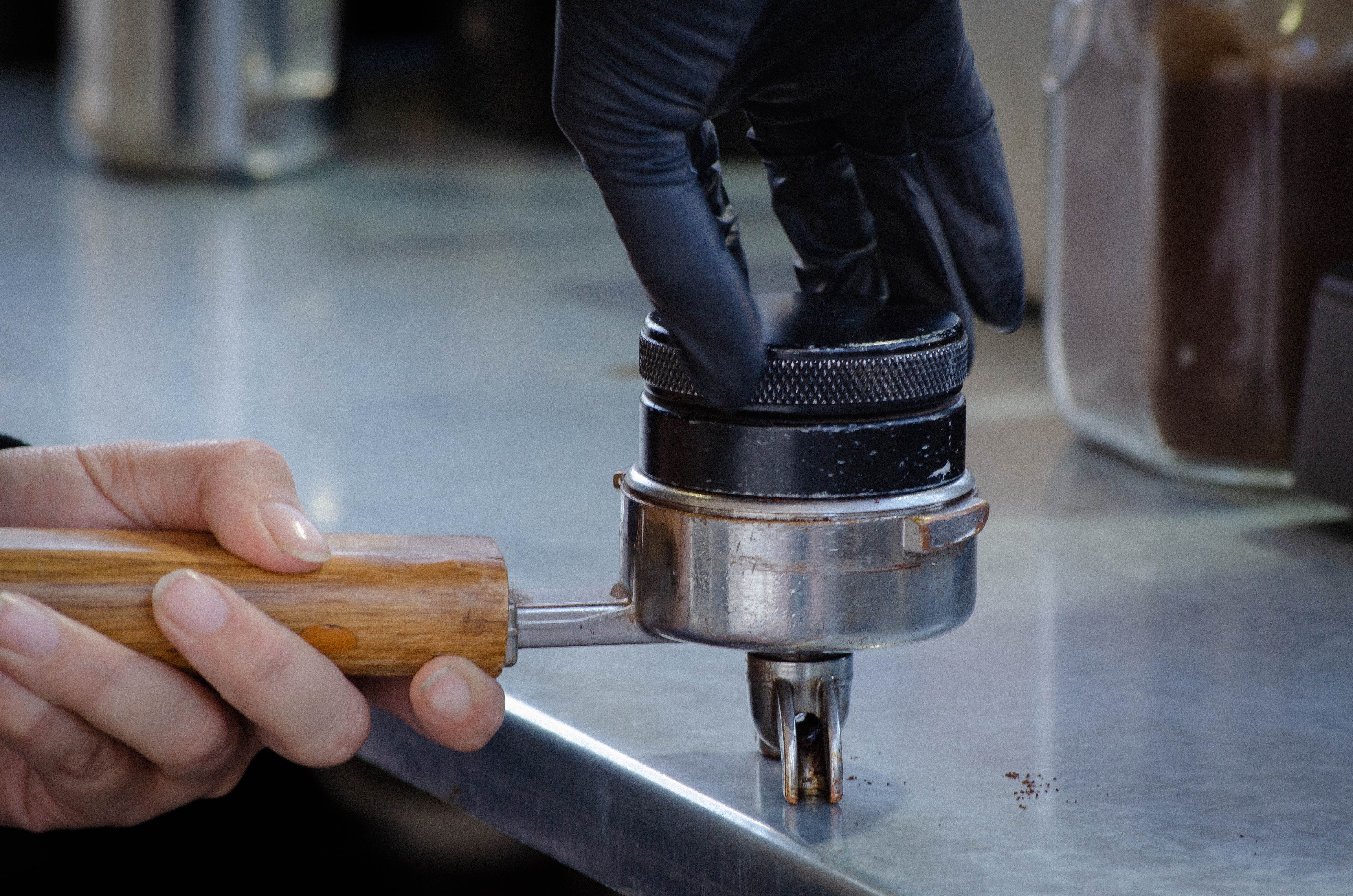 Barista Tamping Coffee Grounds in Café in Tepic · Free Stock Photo