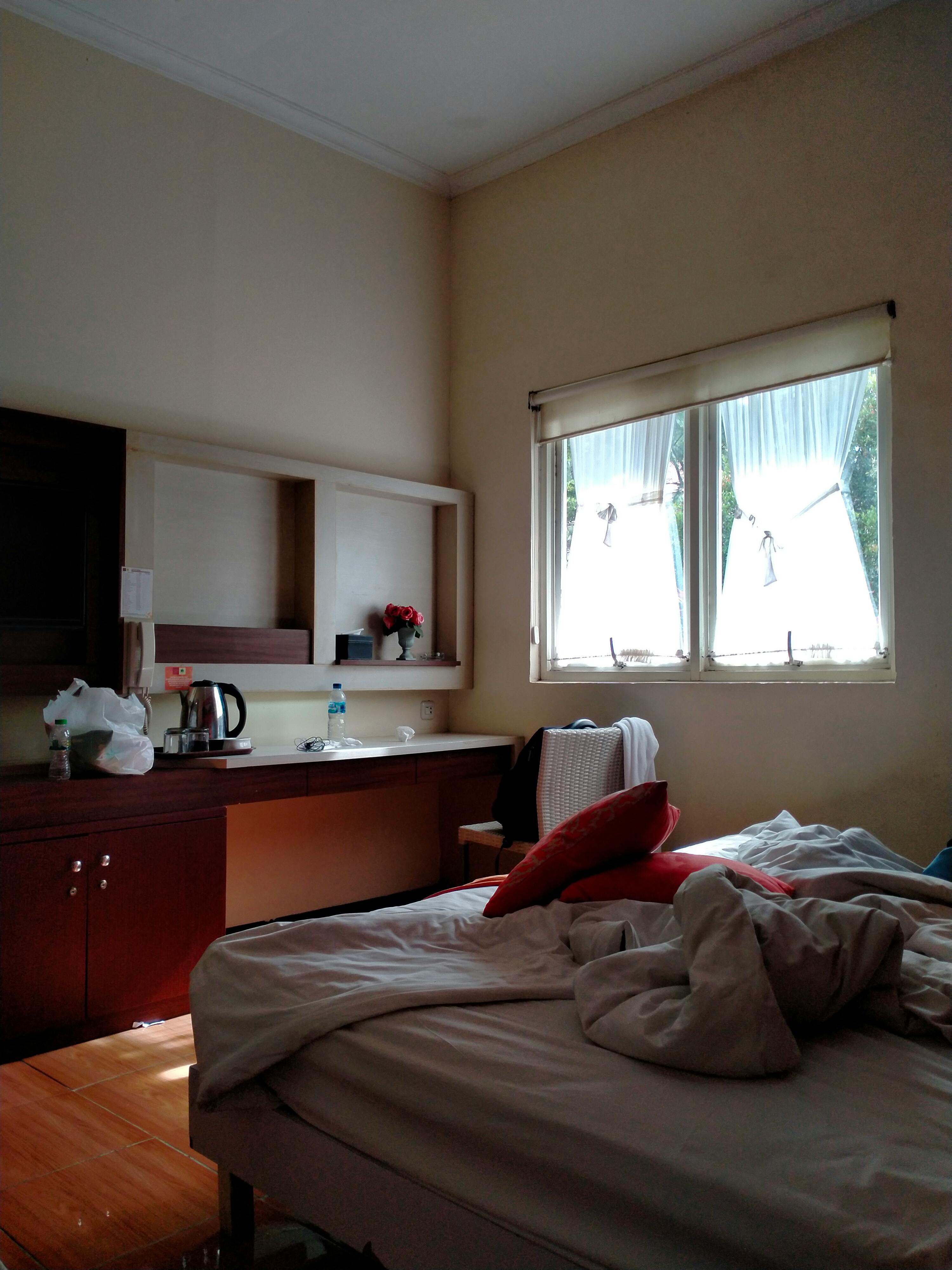 Cozy Sunlit Bedroom with Unmade Bed · Free Stock Photo