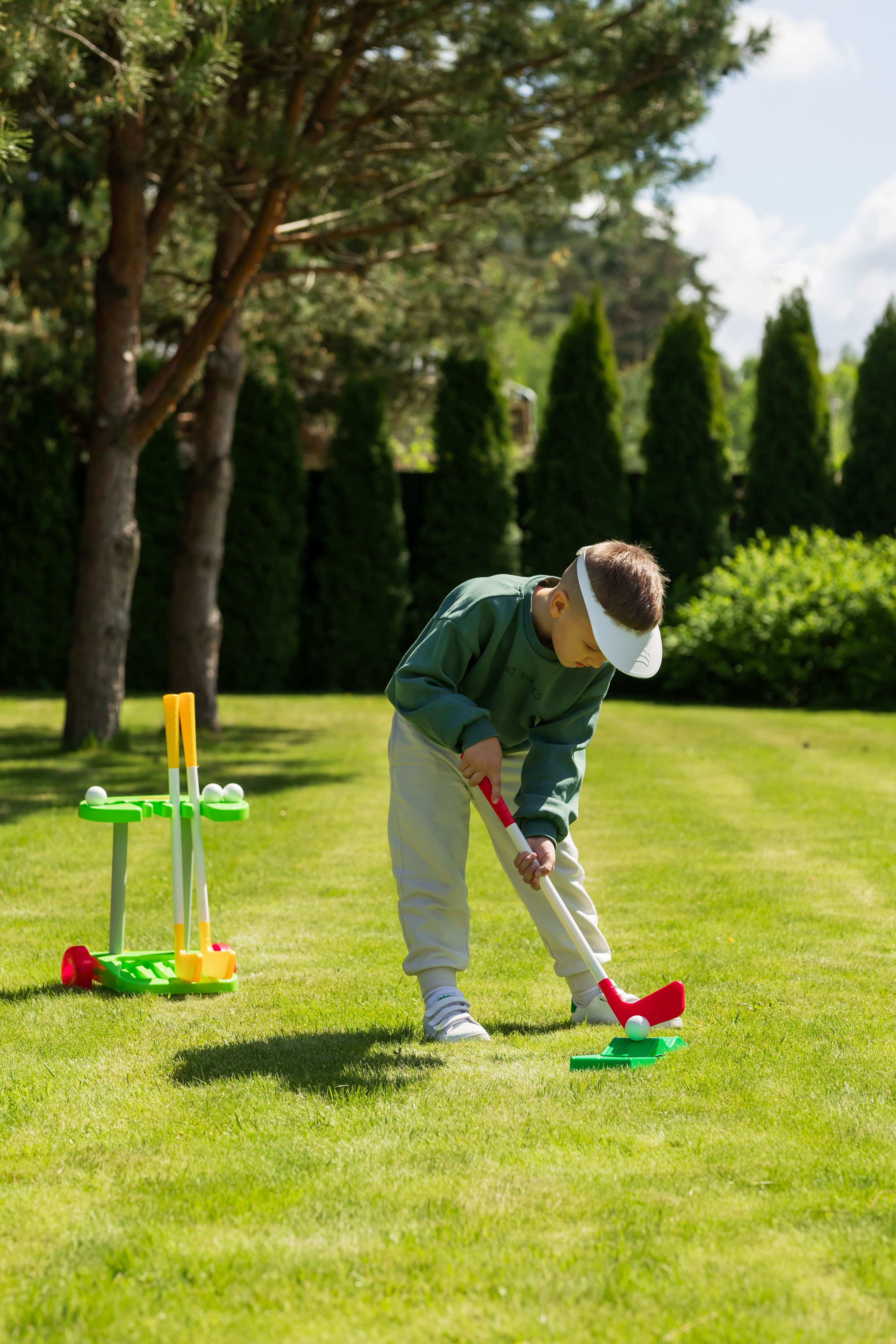 Young Boy Playing Mini Golf in the Backyard · Free Stock Photo