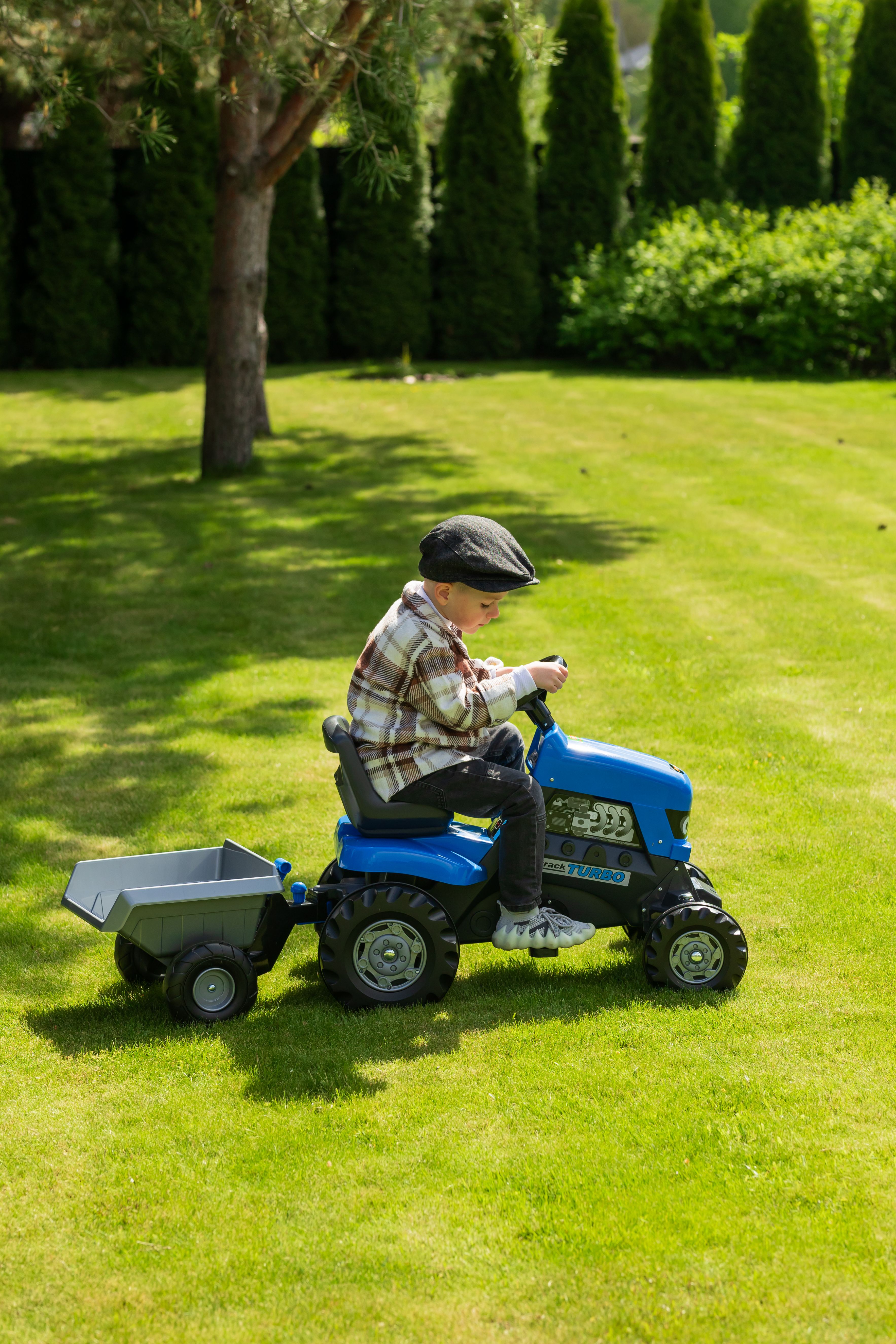 Child Riding Toy Tractor on Sunny Day · Free Stock Photo