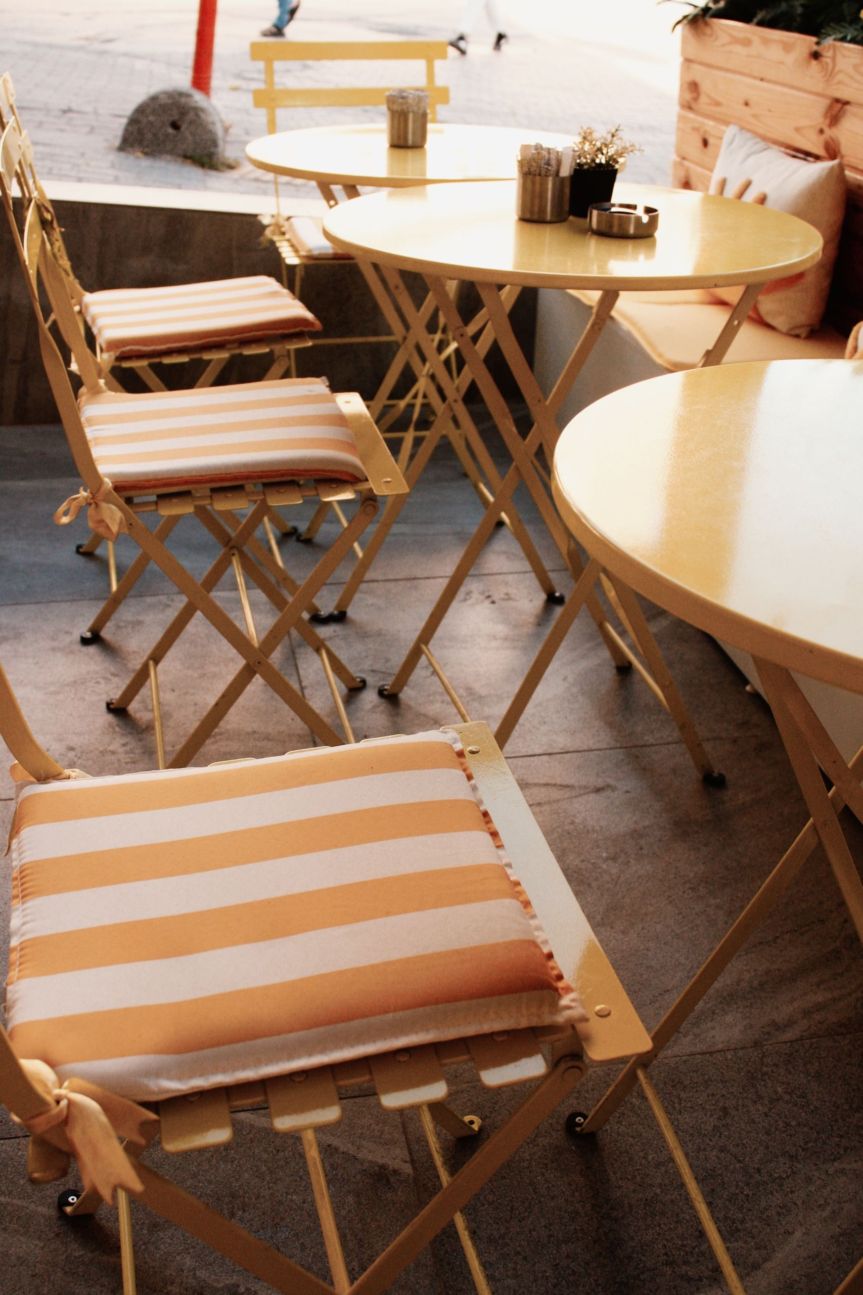 Charming Outdoor Café with Yellow Bistro Seating · Free Stock Photo