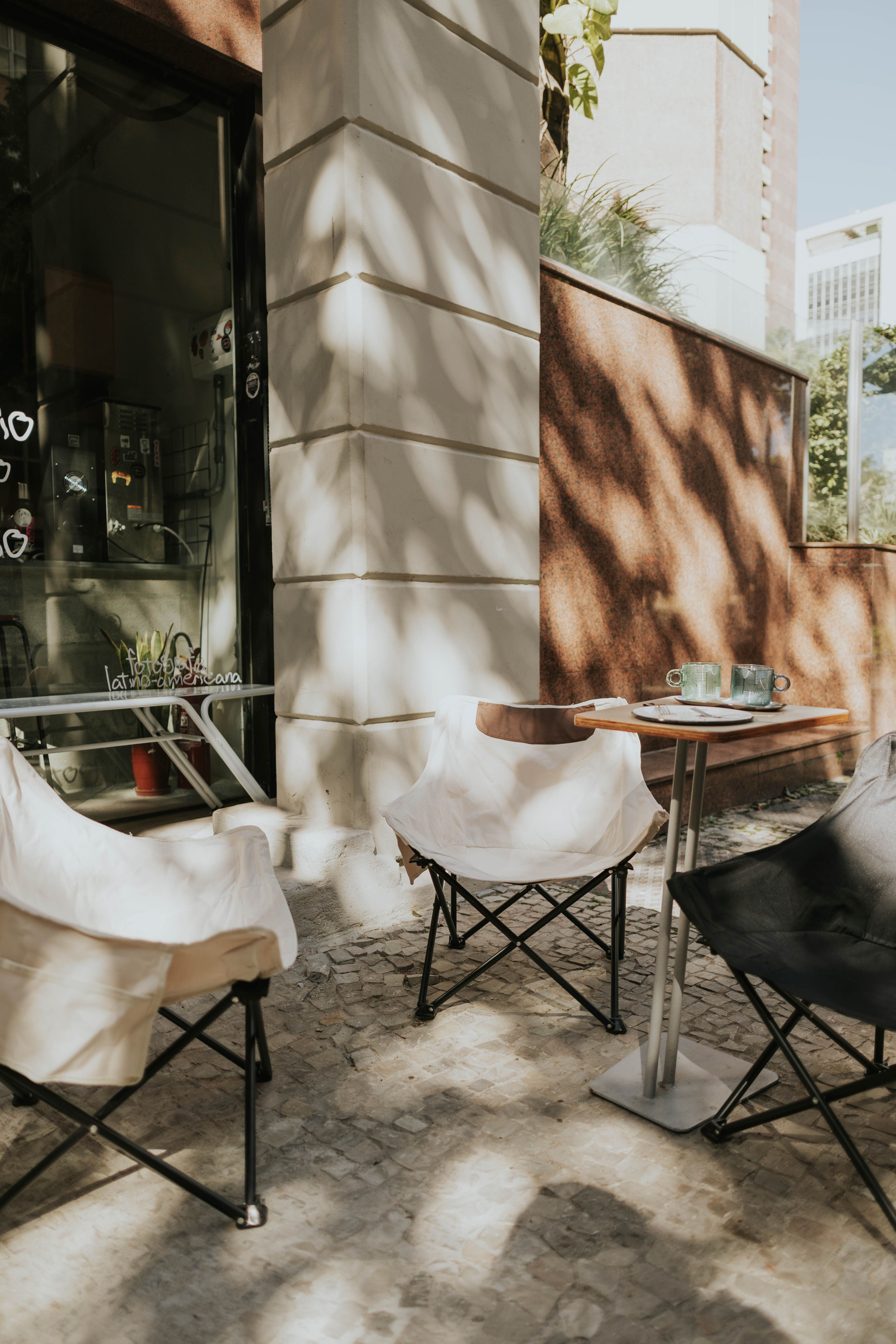 Cozy Outdoor Café with Sunlit Shadows · Free Stock Photo