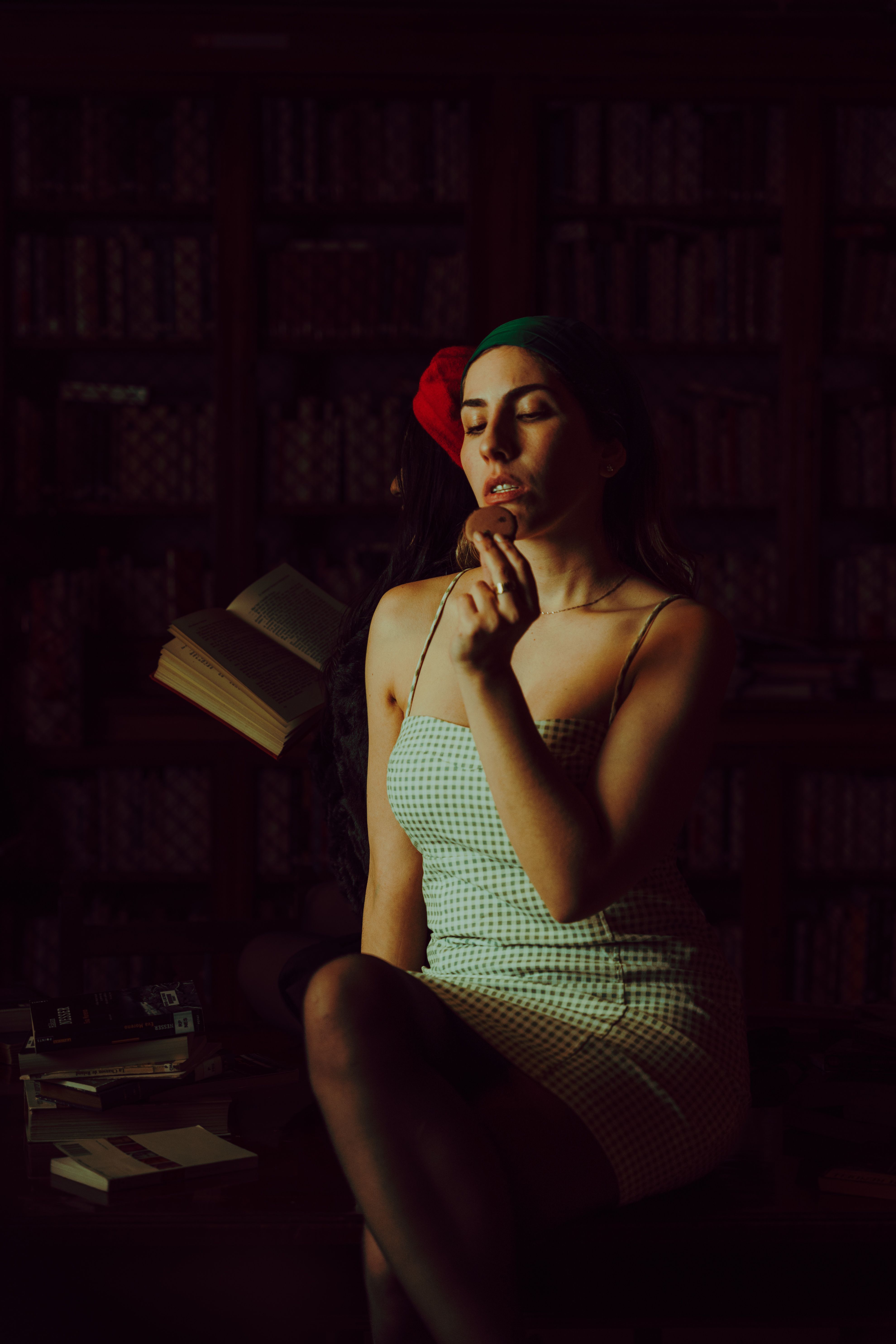 Contemplative Woman in Dimly Lit Library Setting · Free Stock Photo