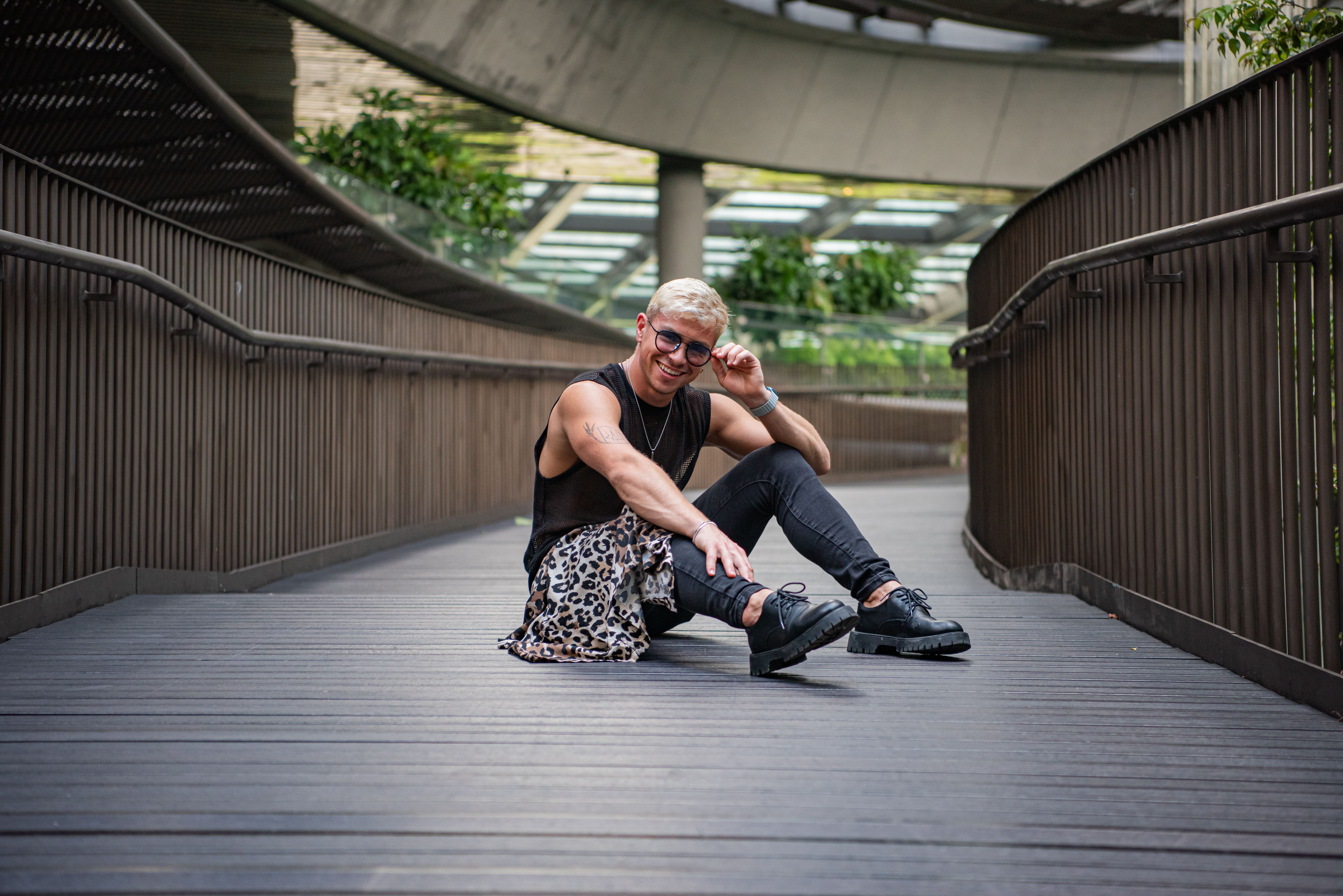 Stylish Person Sitting on Curved Urban Walkway · Free Stock Photo