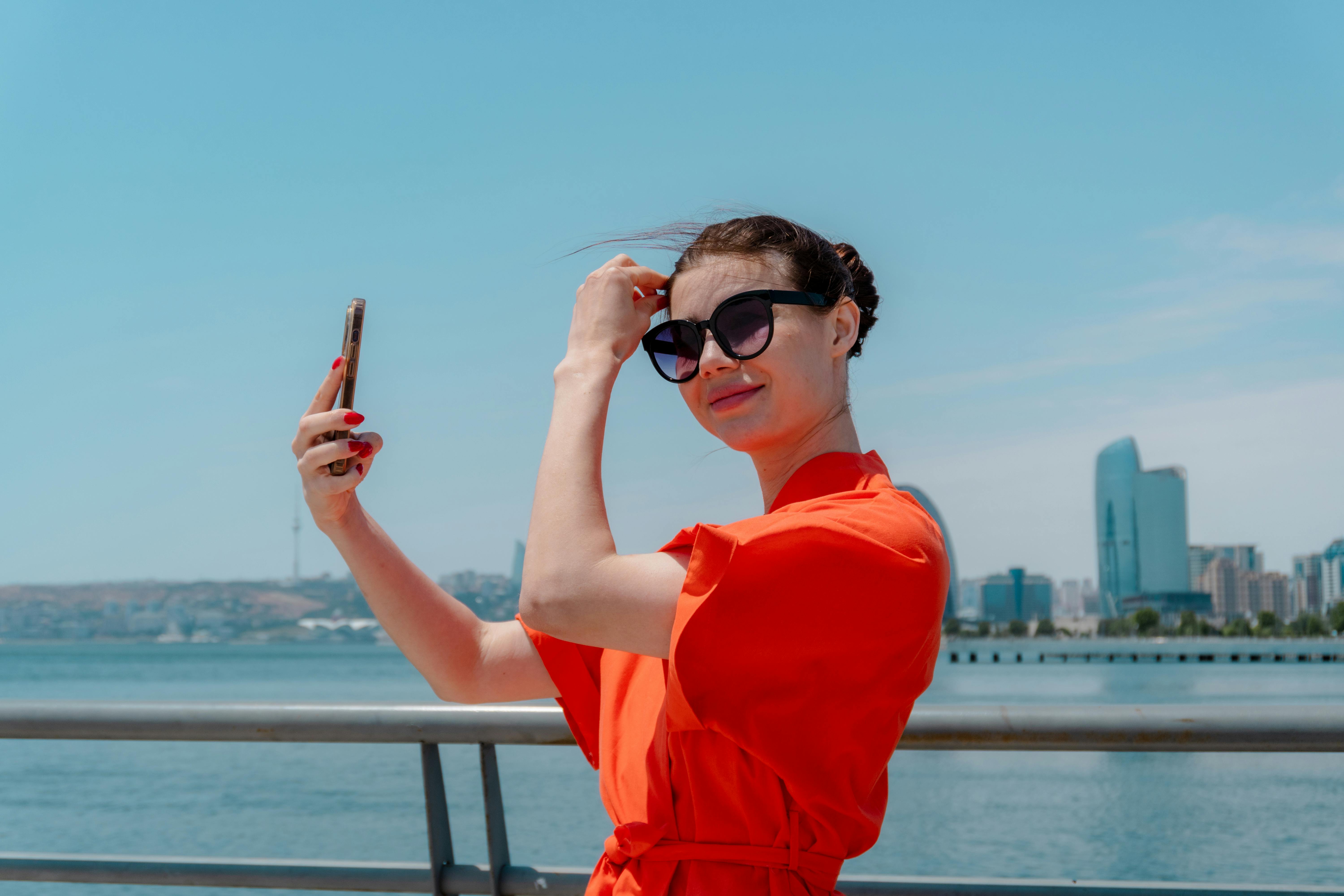 Woman Taking Selfie by Waterfront Skyline · Free Stock Photo