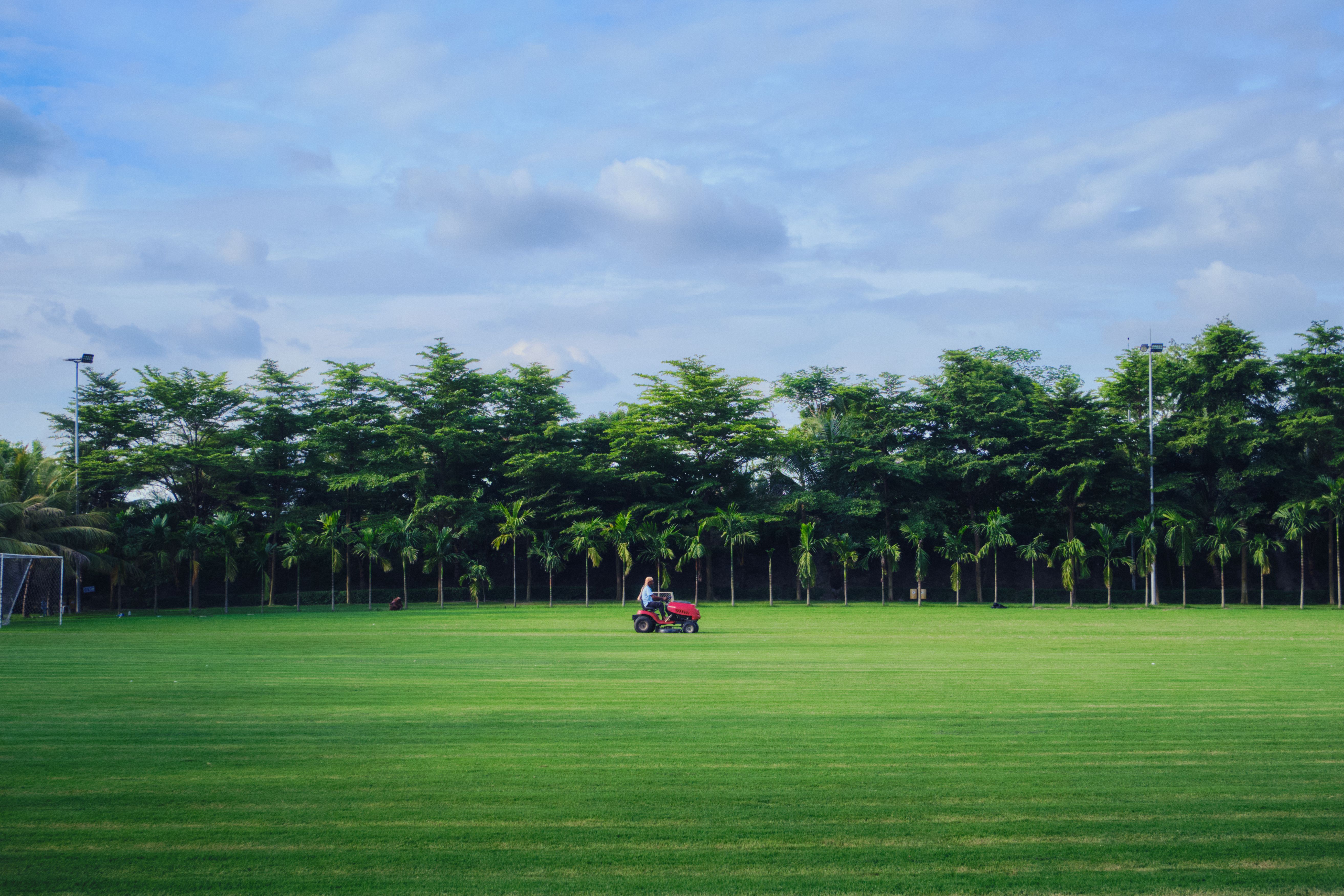 Man Mowing Lawn on Golf Course in Dhaka · Free Stock Photo