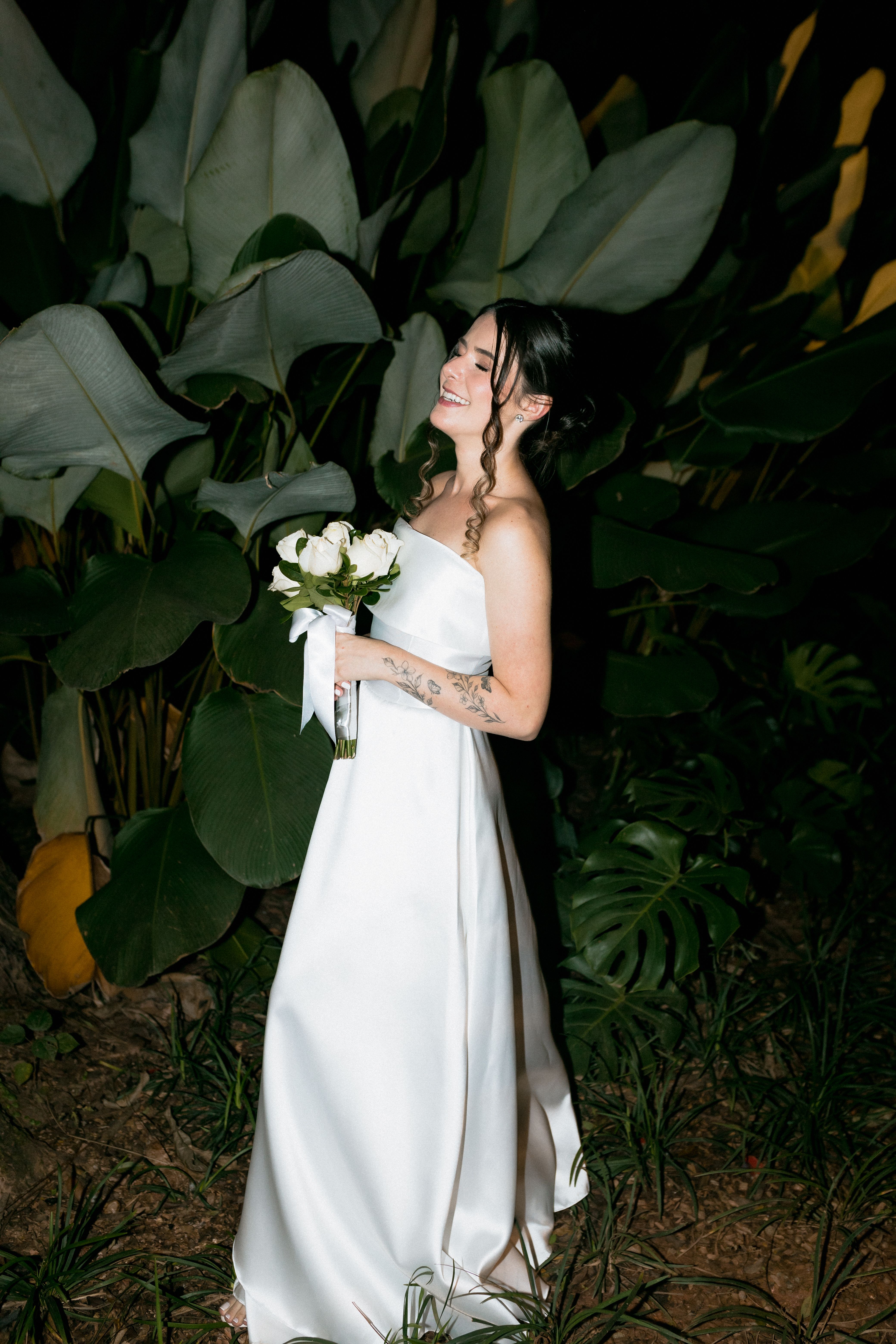 Elegant bride posing with bouquet at night · Free Stock Photo