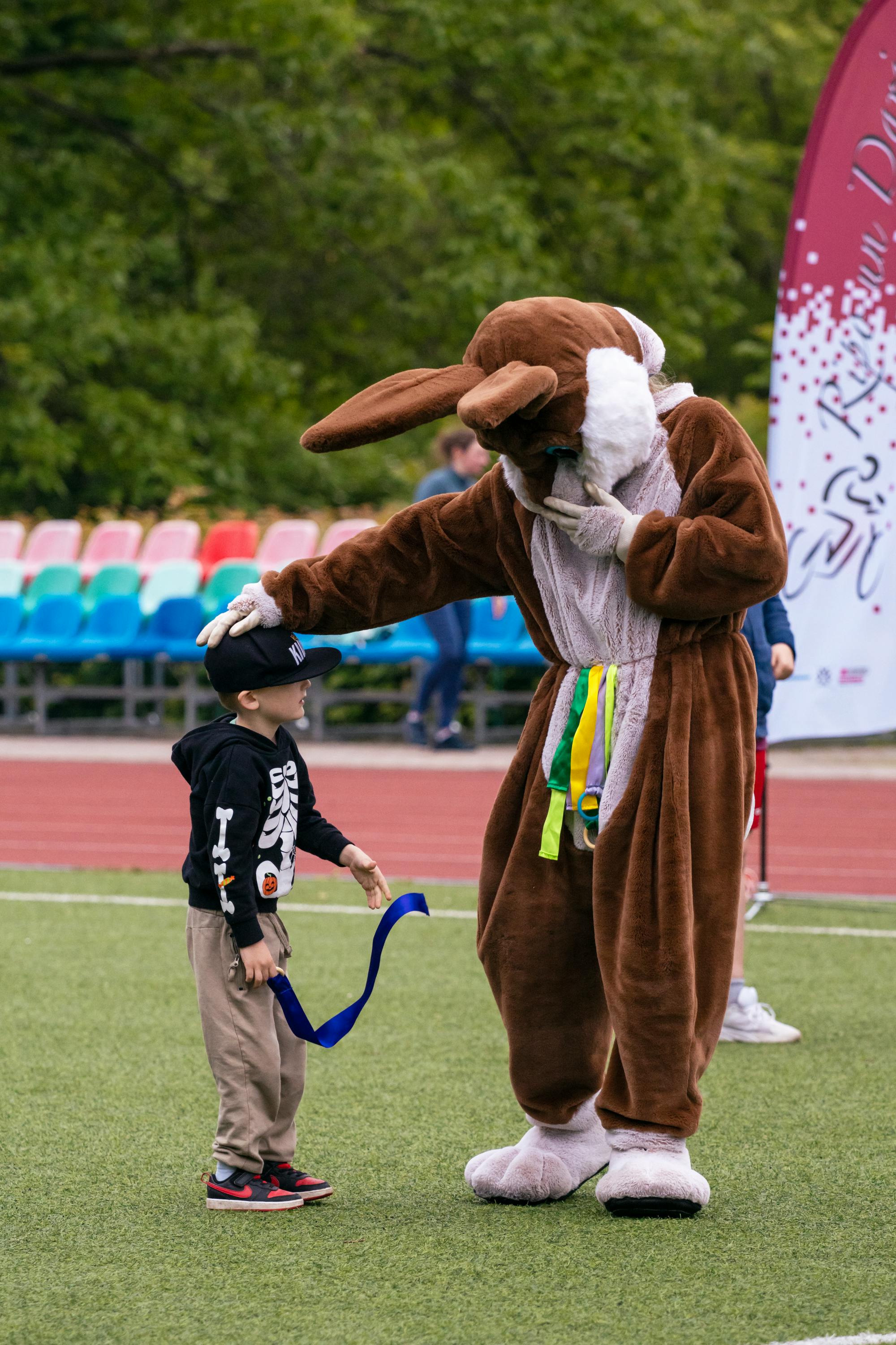 Child Receiving Award from Bunny Mascot Outdoors · Free Stock Photo