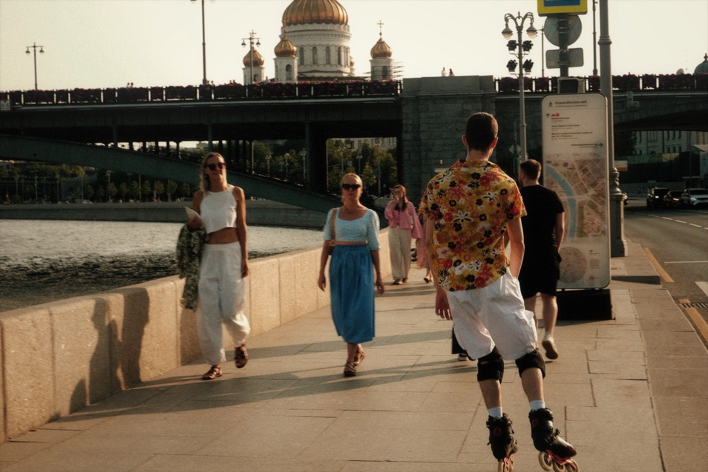 People Leisurely Strolling on Riverside Walkway · Free Stock Photo