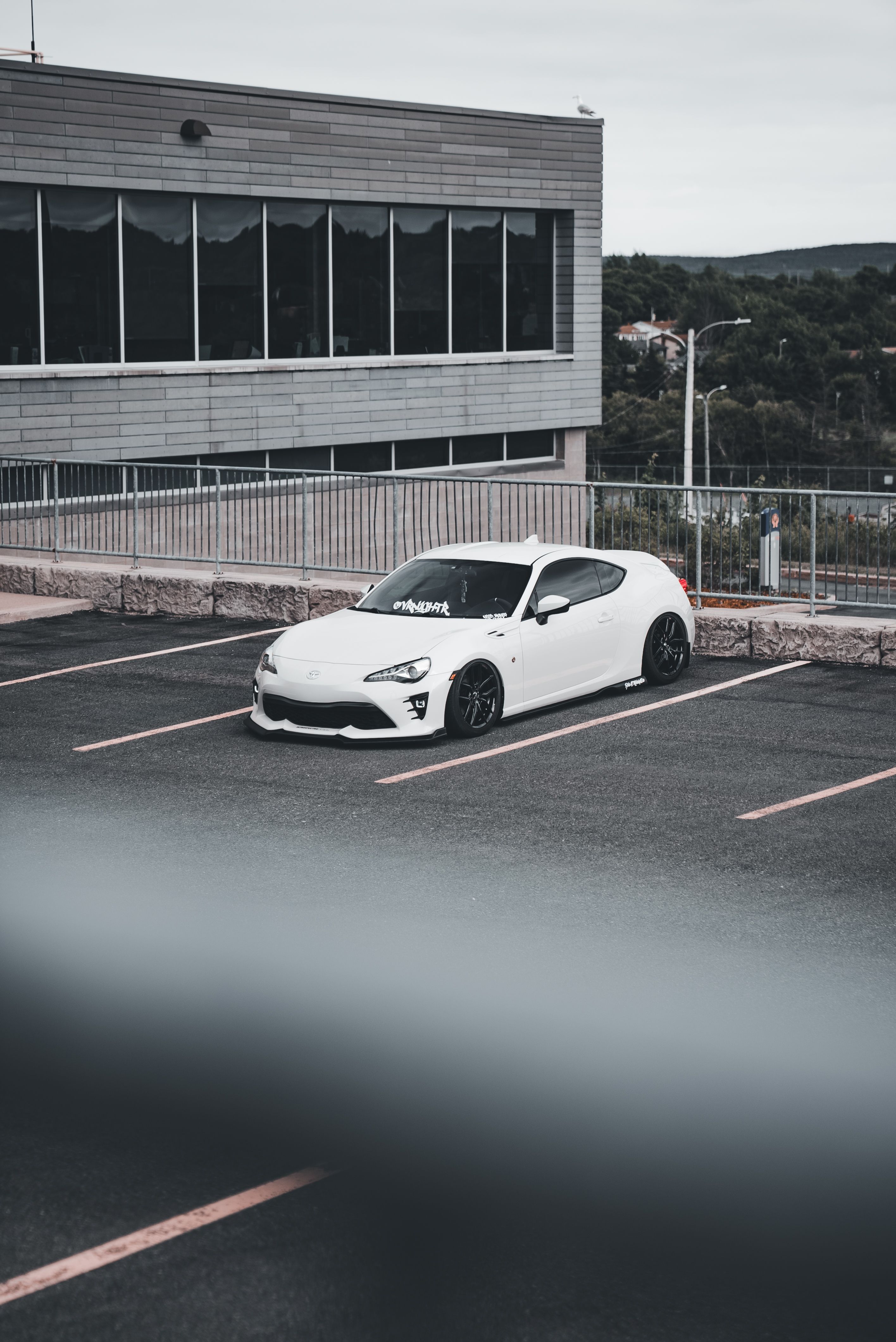 White Sports Car Parked Outside Office Building · Free Stock Photo