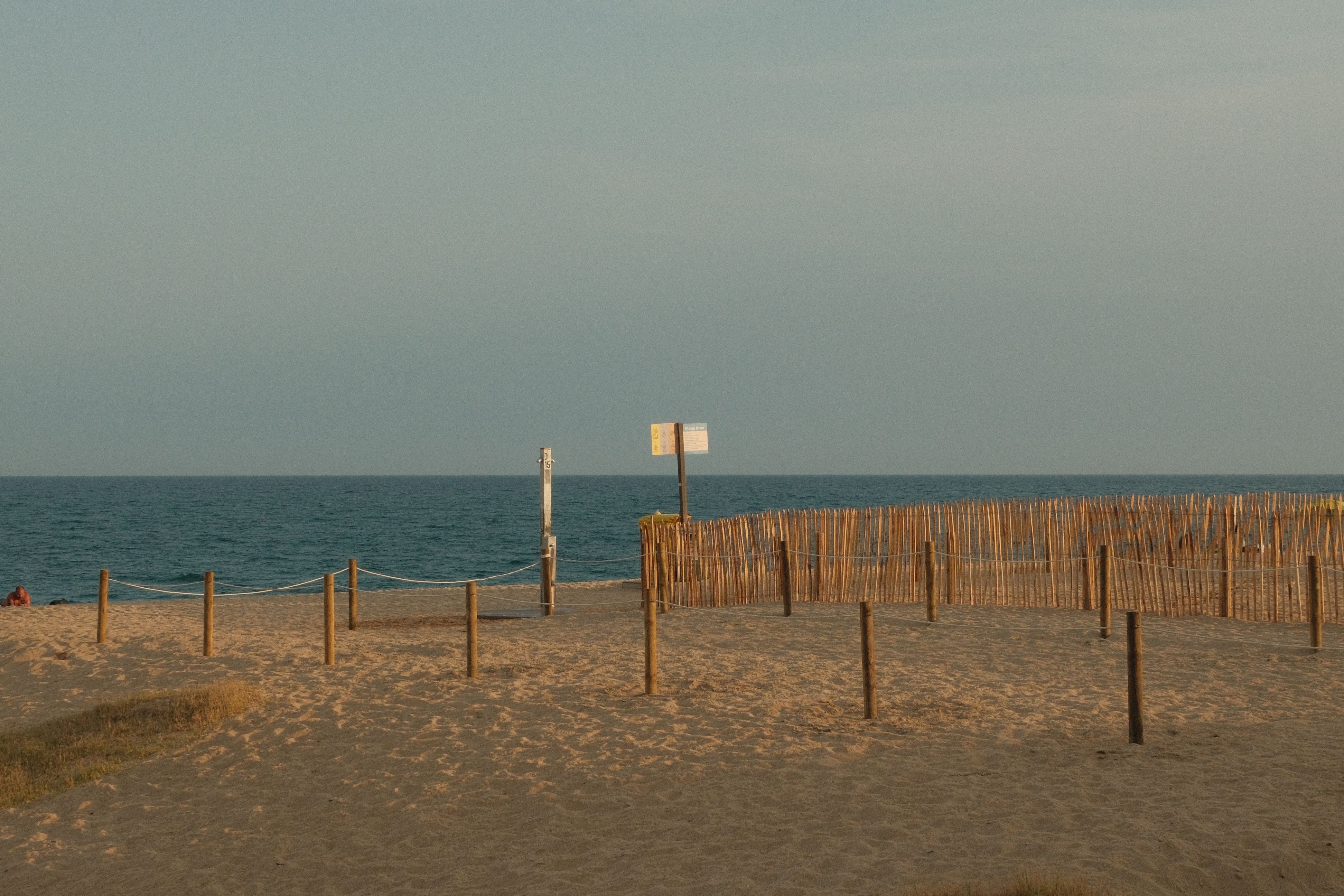 Serene Coastal Beach Scene with Fencing · Free Stock Photo