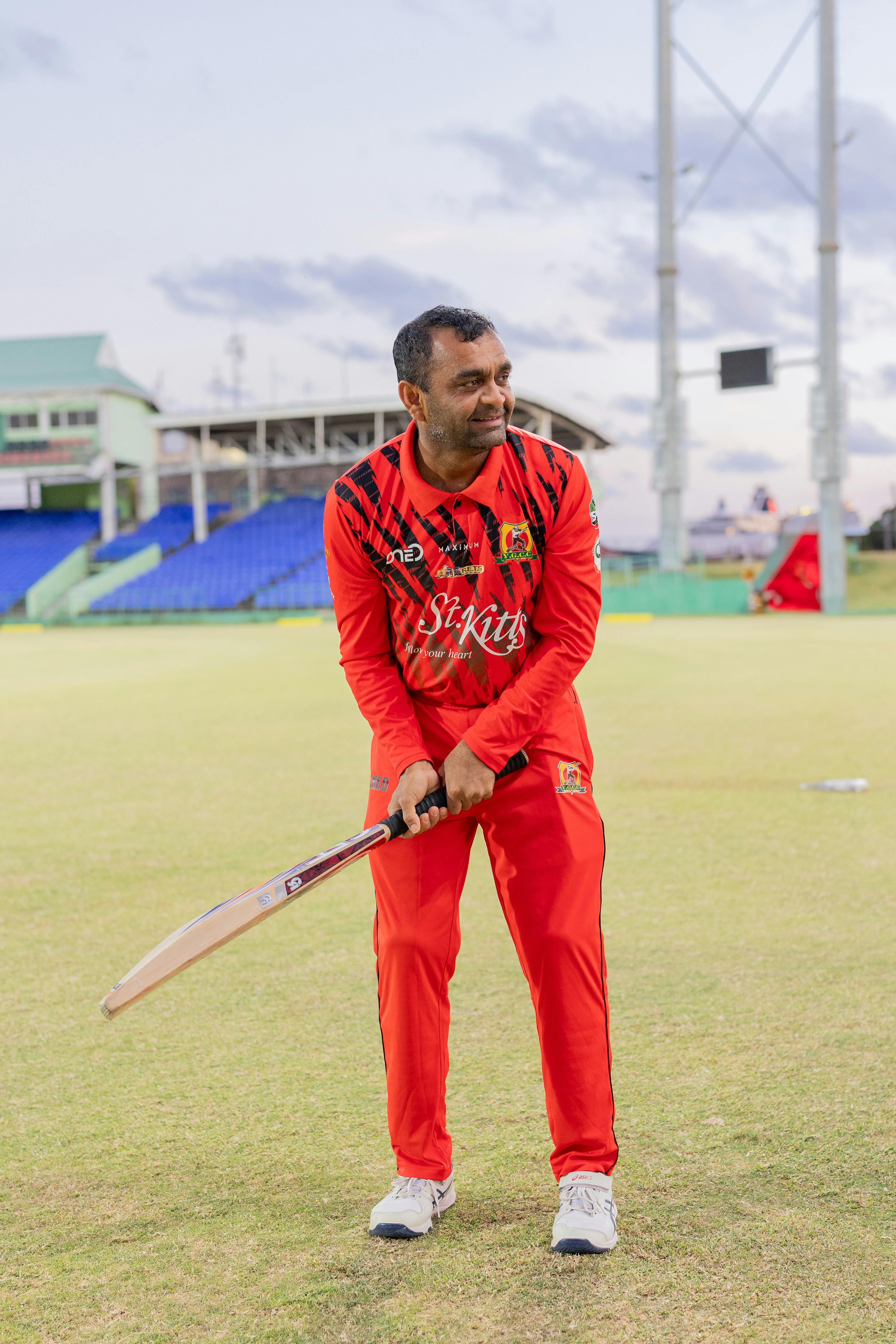Cricketer in Red Uniform Playing on Saint Kitts Field · Free Stock Photo
