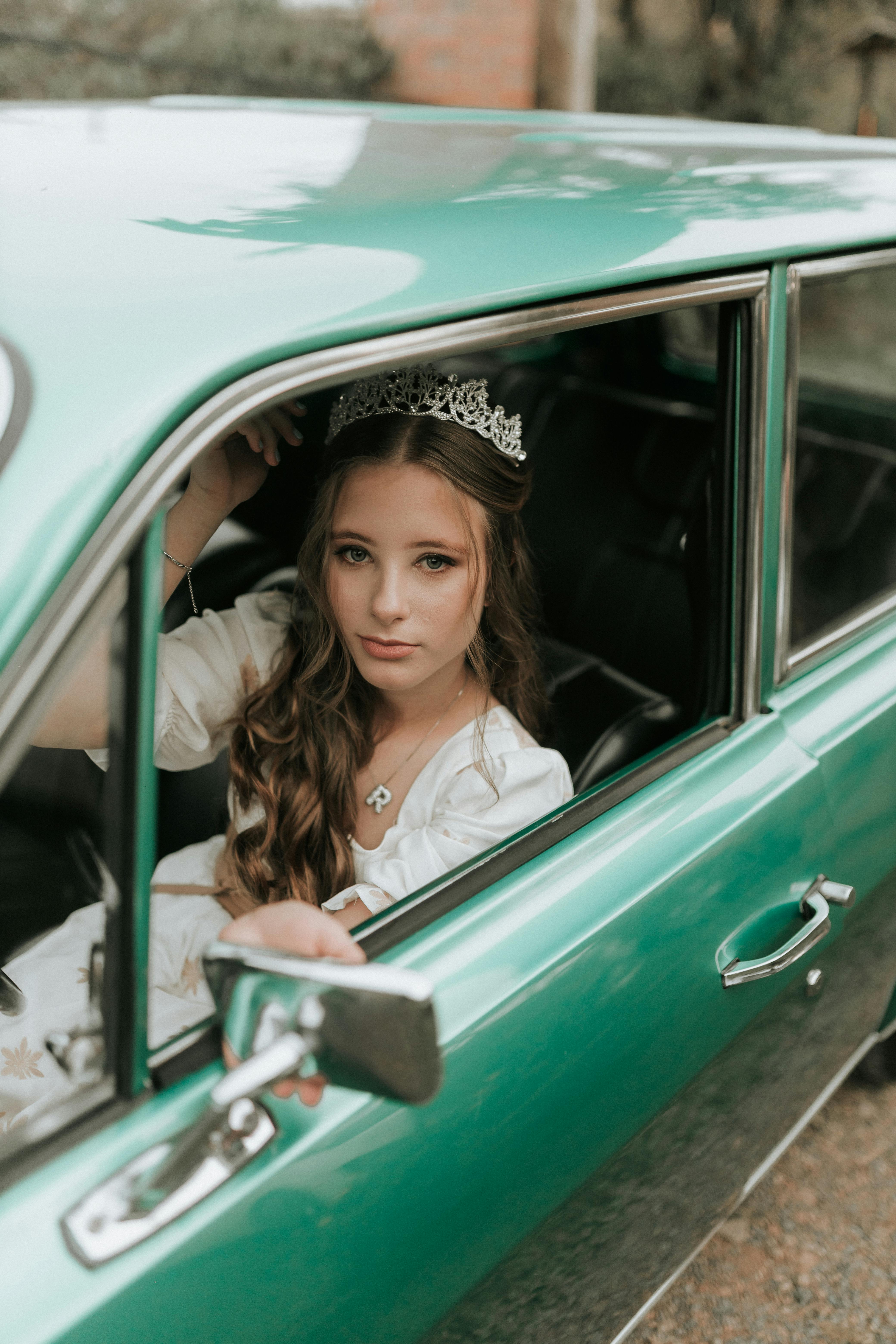 Young Woman in Vintage Car with Tiara · Free Stock Photo