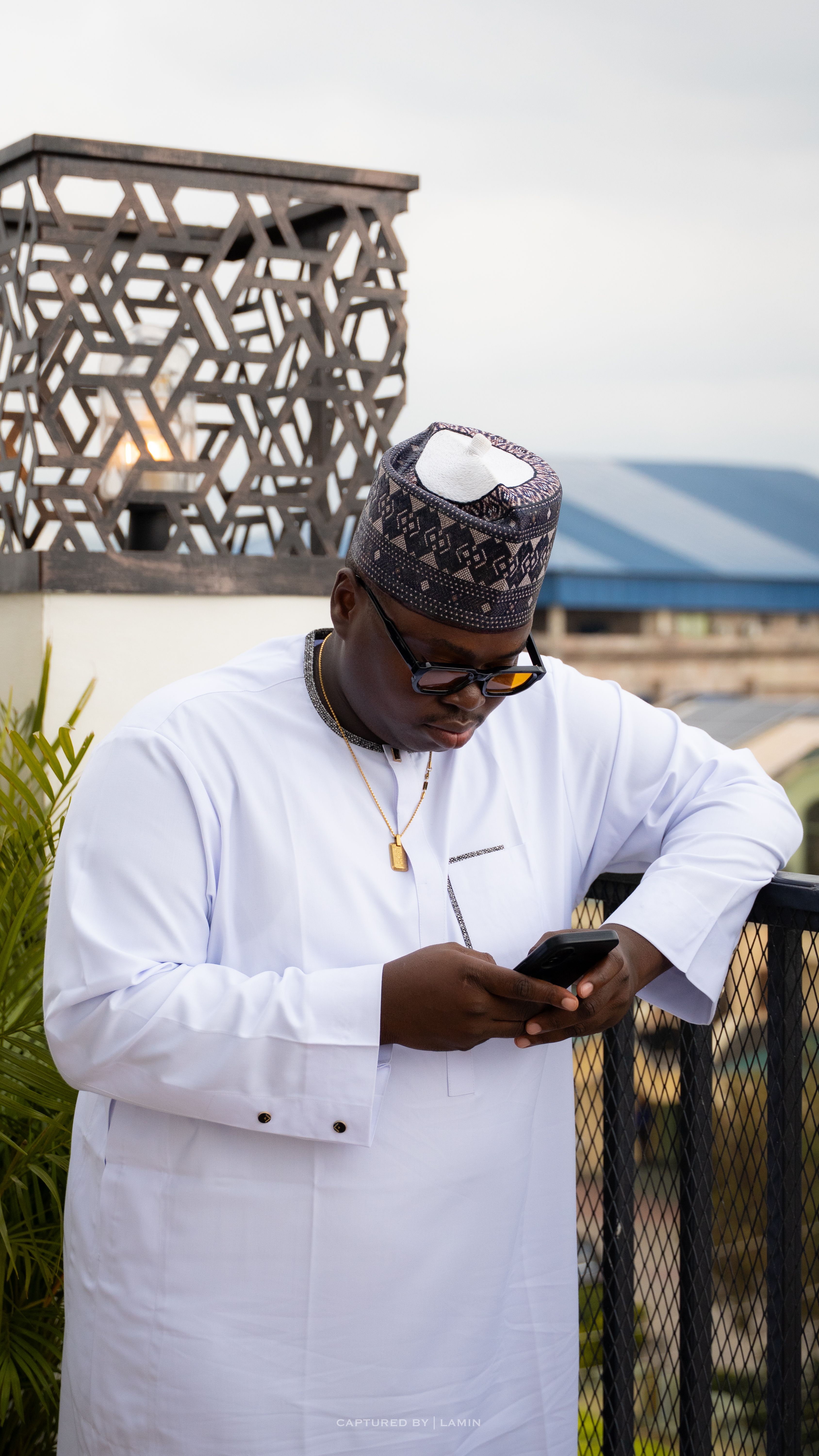 Man in Traditional Nigerian Attire Using Smartphone · Free Stock Photo