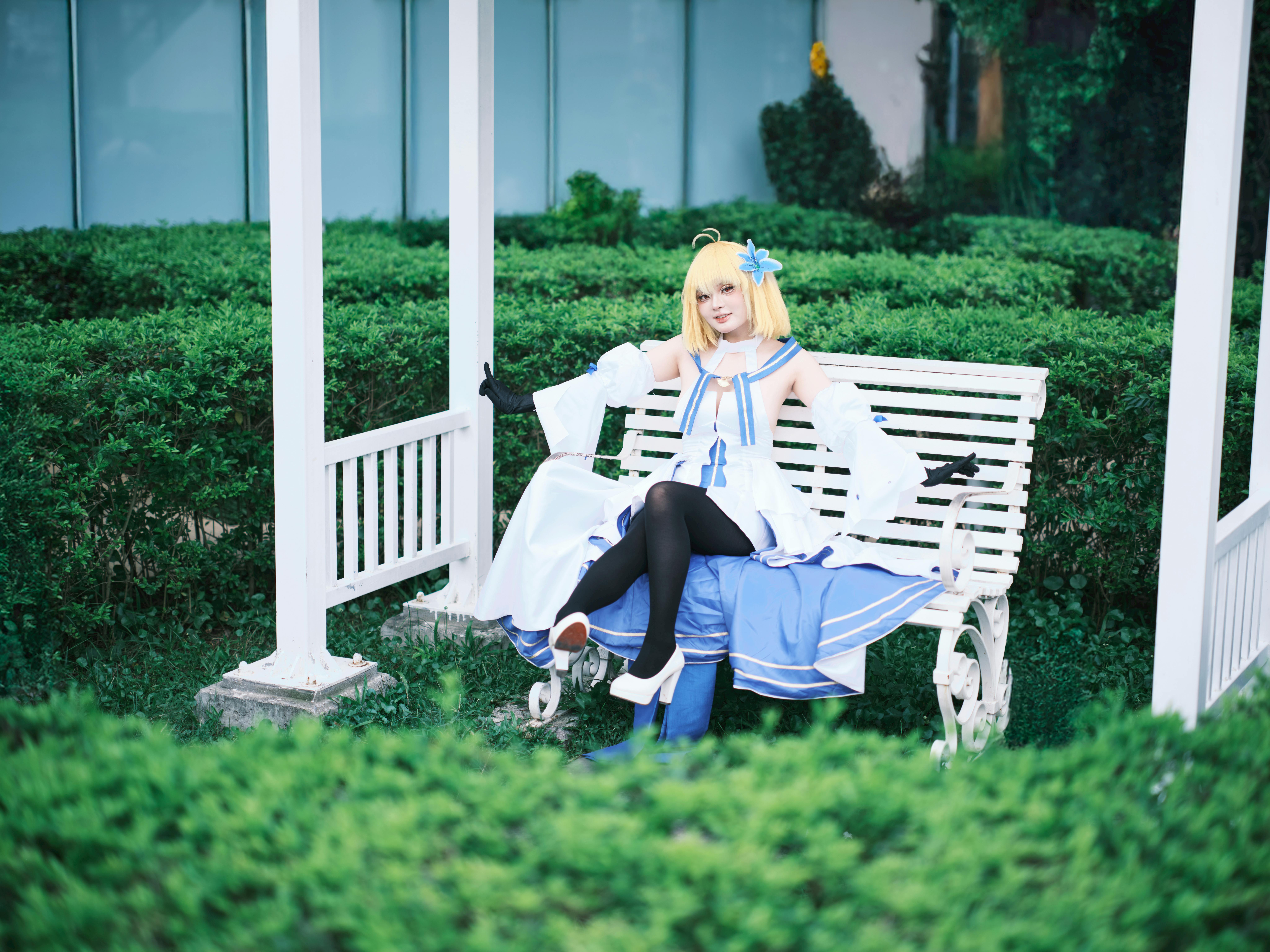 Cosplayer in Anime Costume on Garden Bench Outdoors · Free Stock Photo