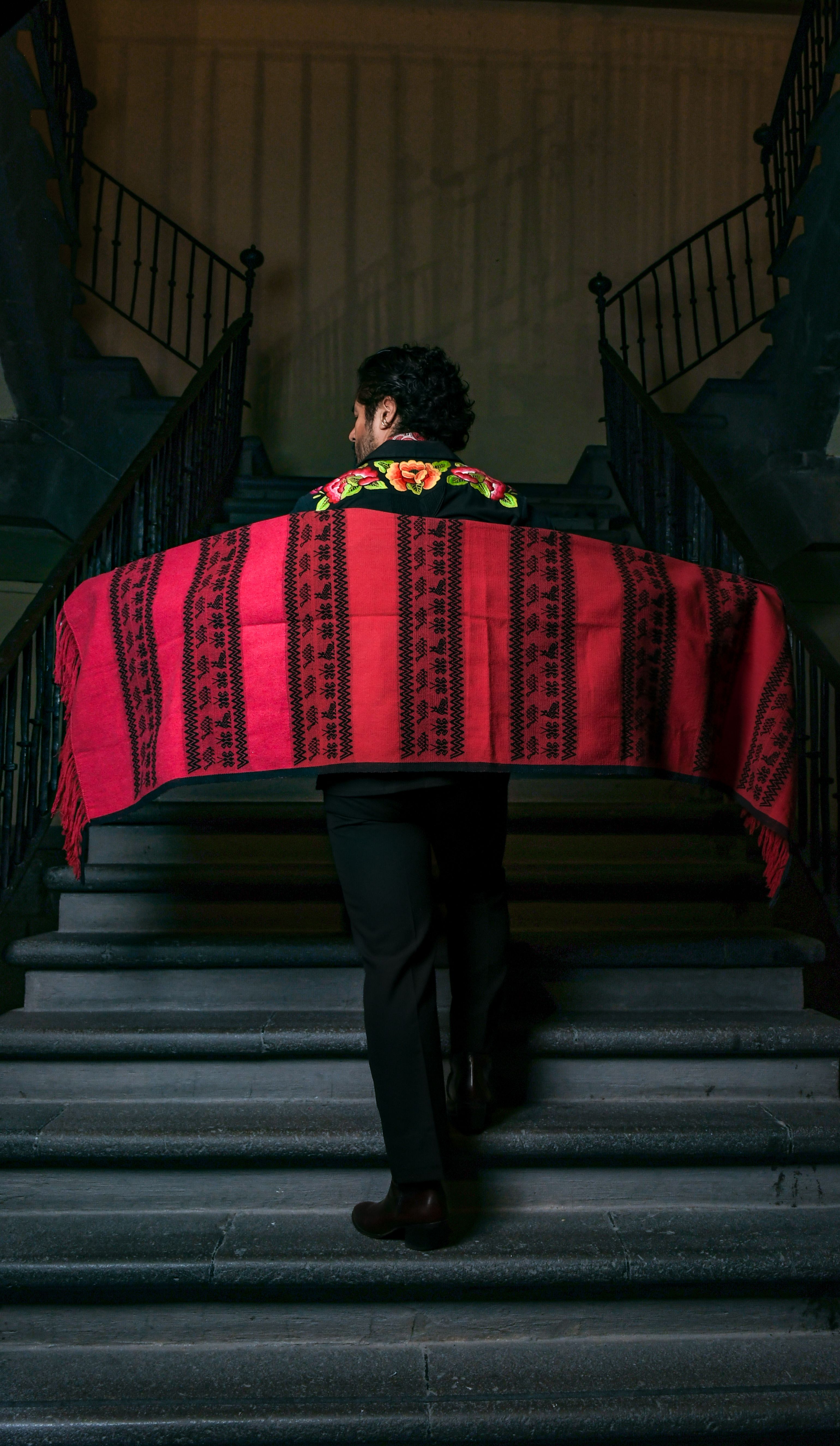 Man Carrying a Red Mexican Cloth Indoors · Free Stock Photo