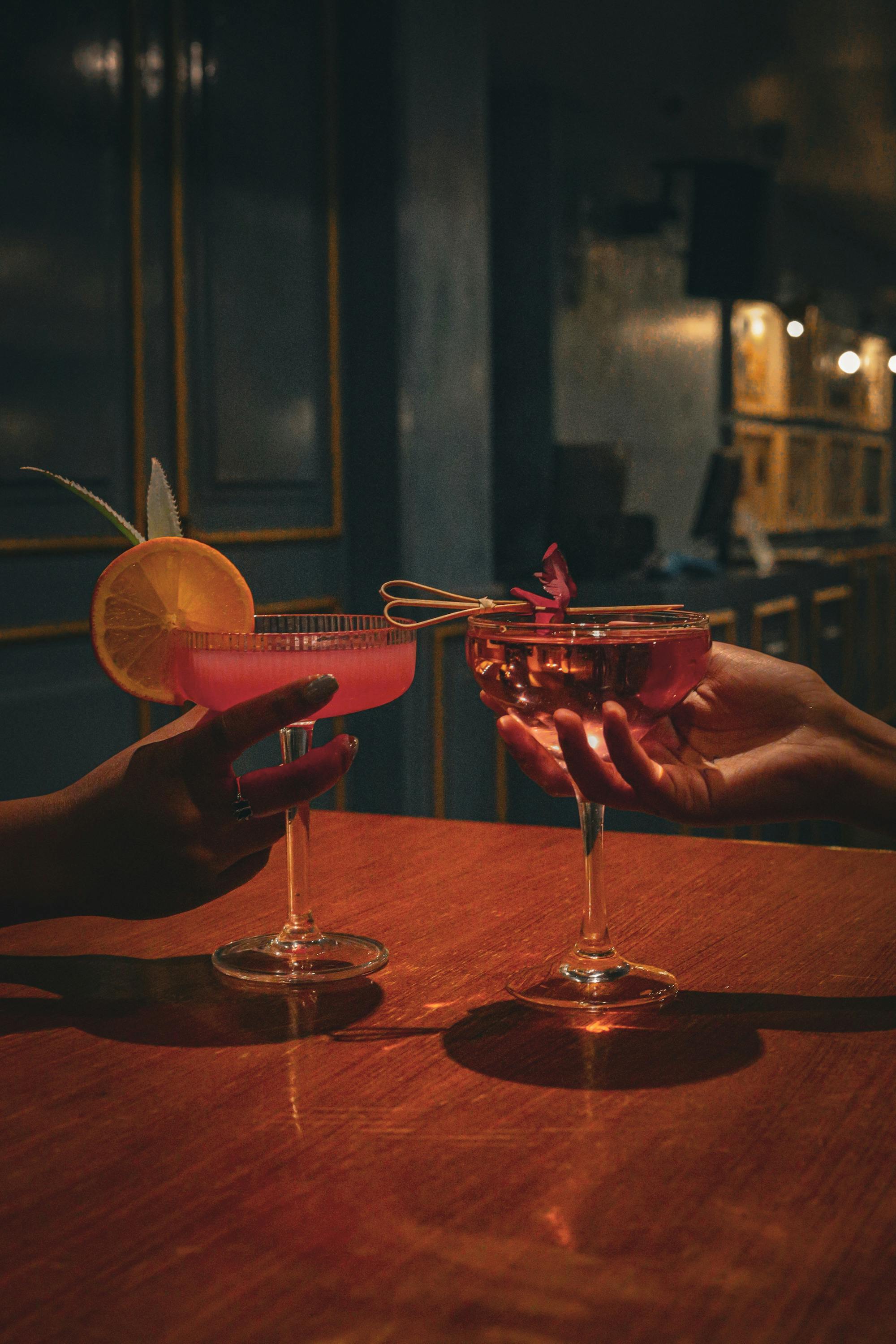 Elegant Cocktail Toast in Dimly Lit Bar · Free Stock Photo
