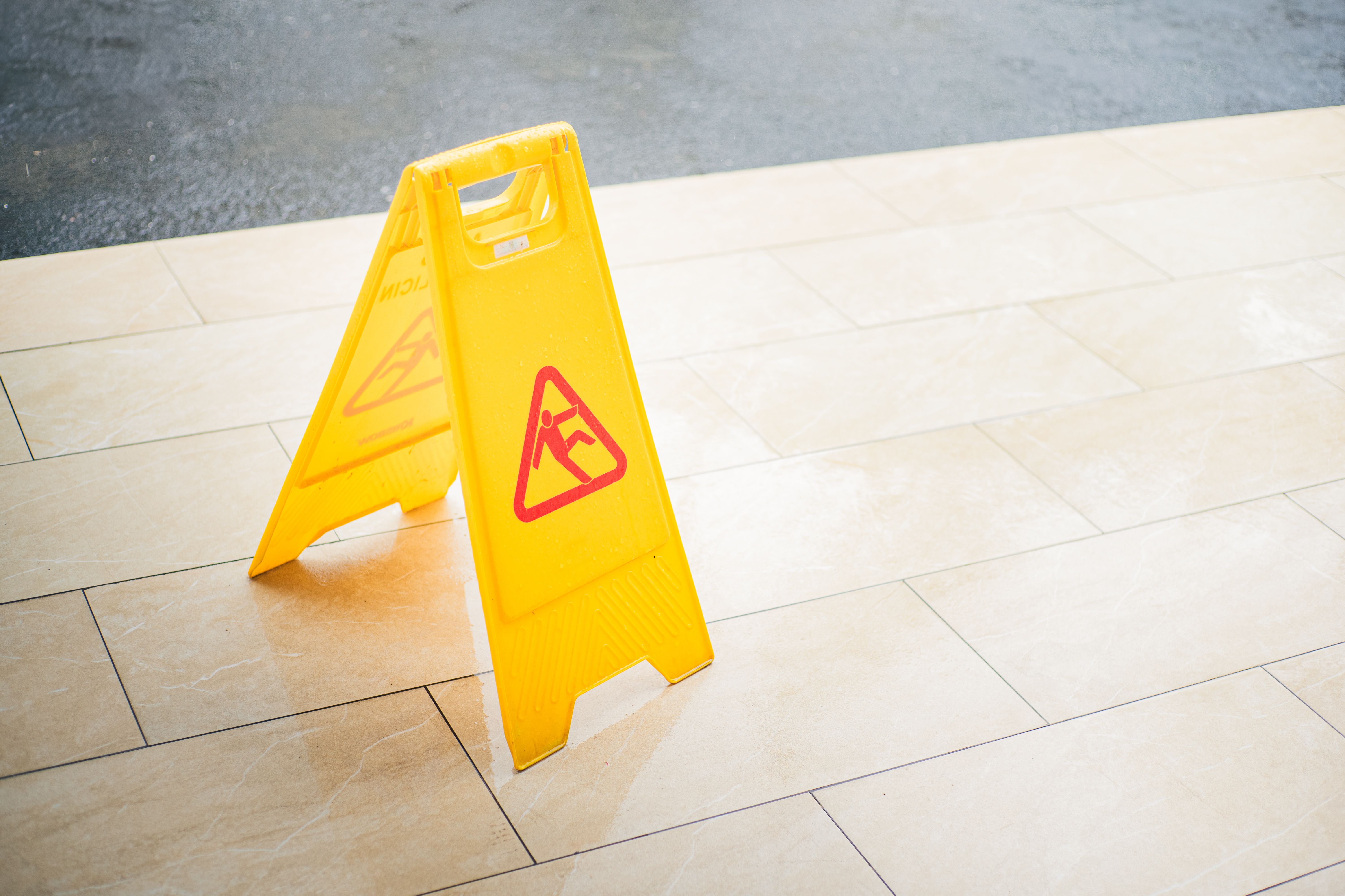 Bright Yellow Wet Floor Caution Sign on Tile Floor · Free Stock Photo