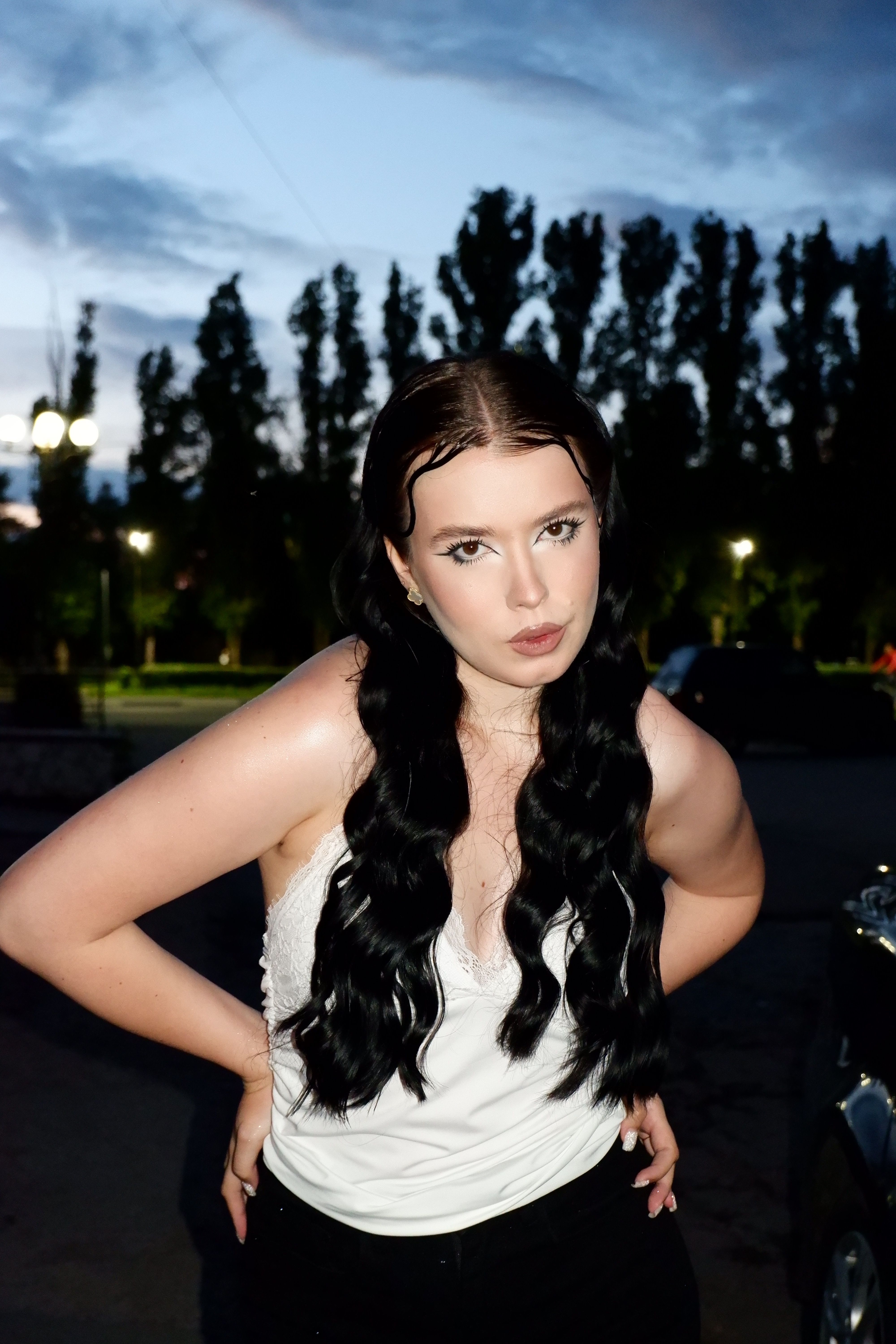 Confident Woman Posing Outdoors at Twilight · Free Stock Photo