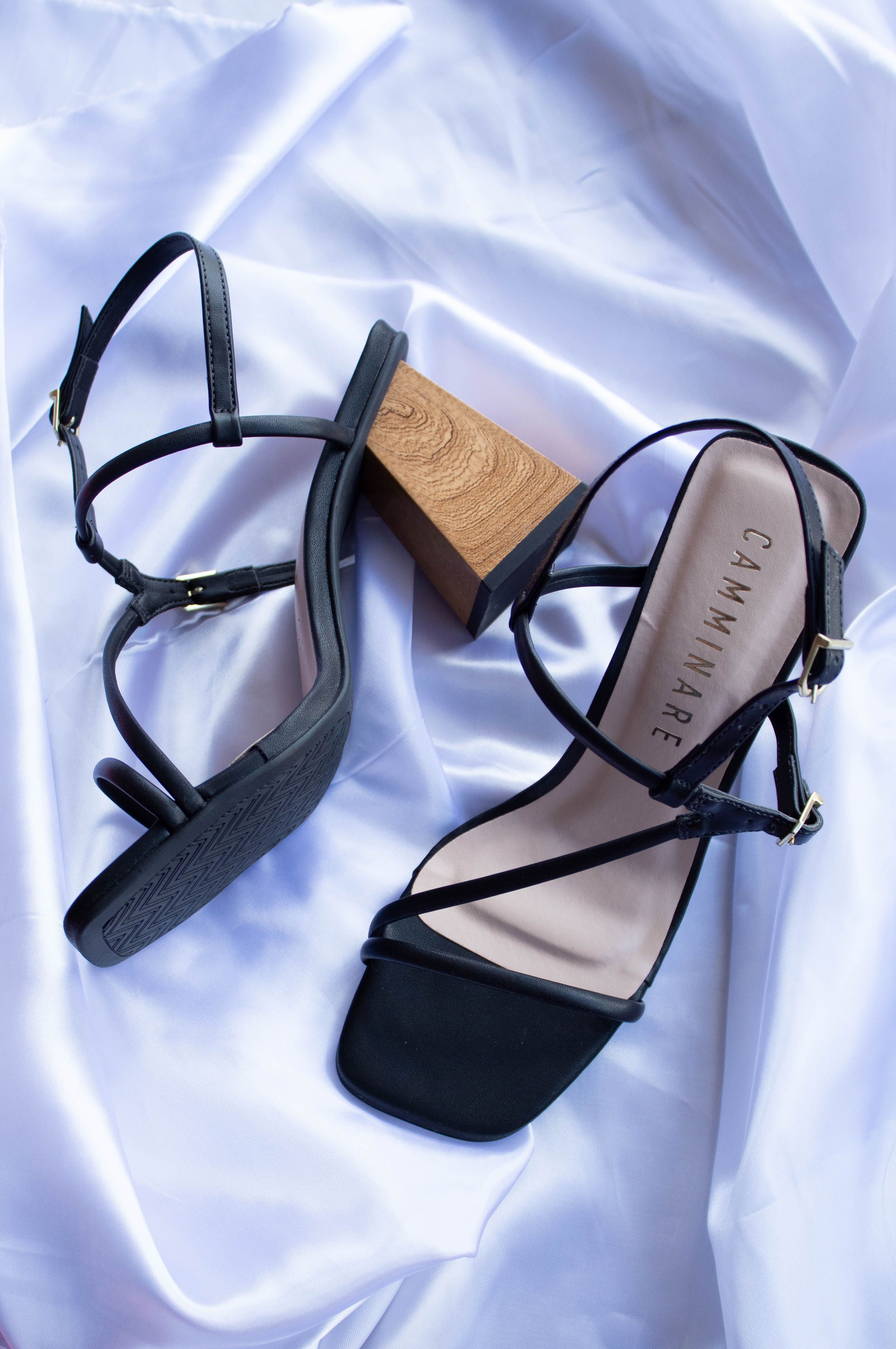 Elegant Black Strappy Sandals on Satin Fabric · Free Stock Photo