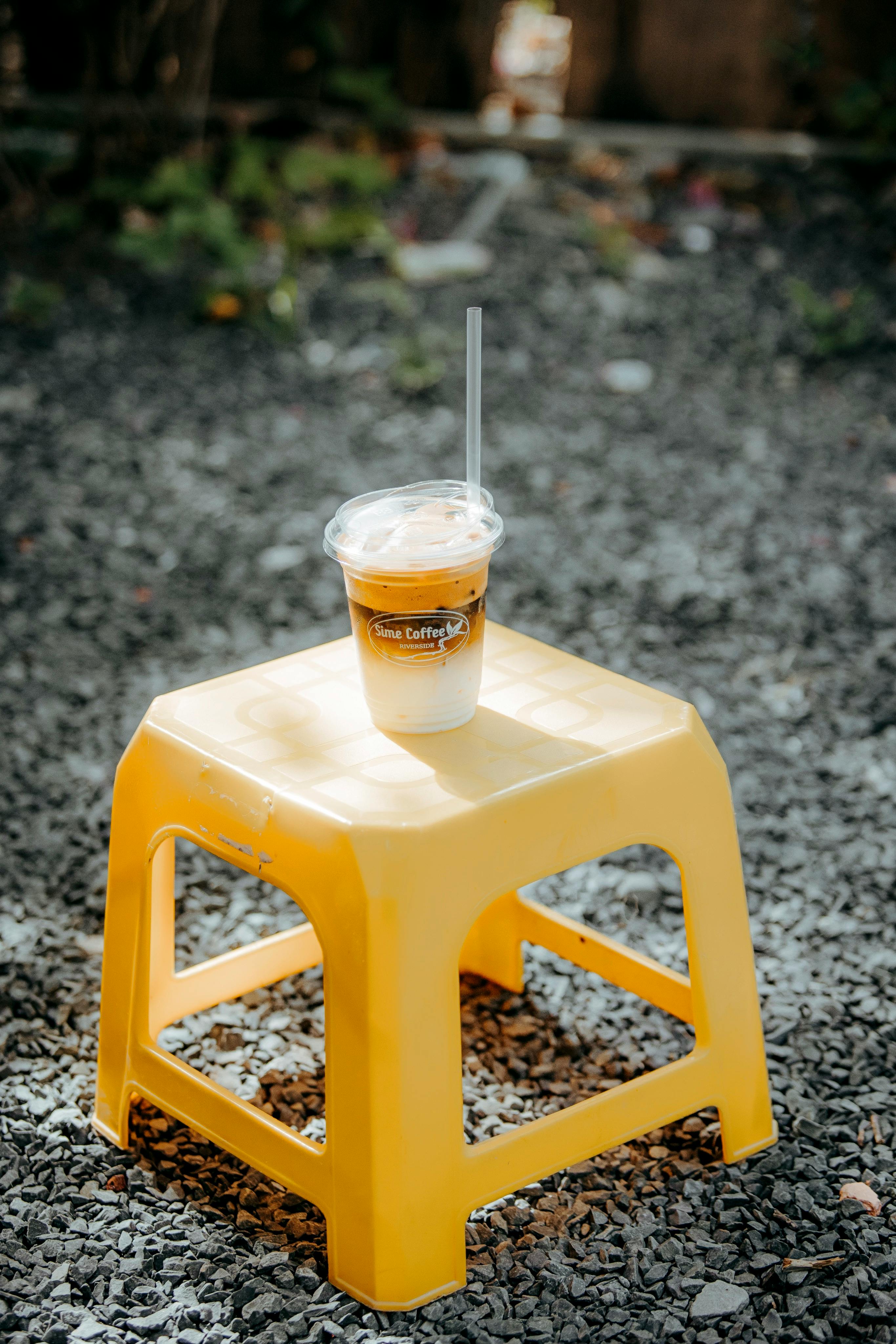 Iced Coffee on Yellow Outdoor Stool · Free Stock Photo