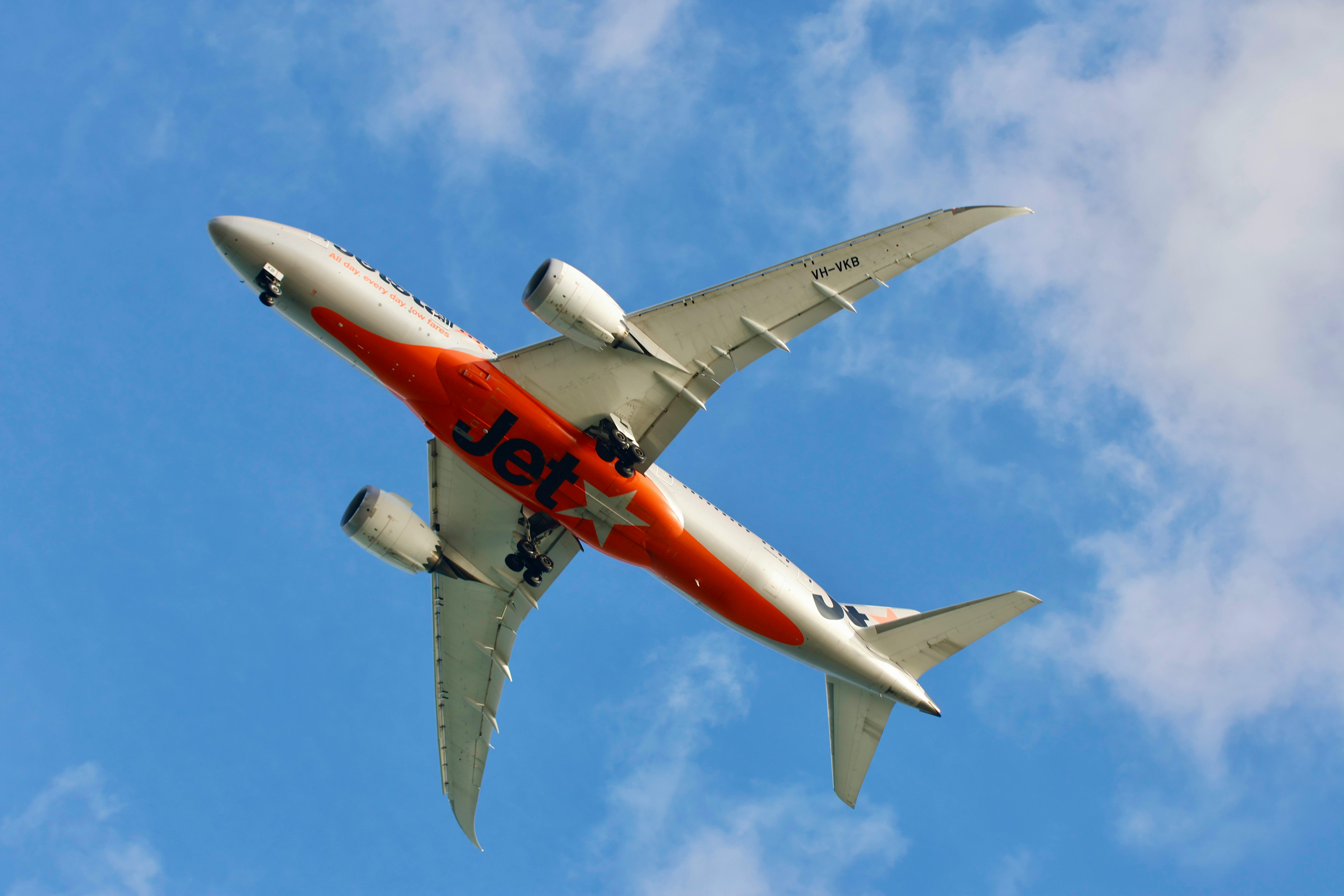 Jetstar Airplane Flying Overhead in Blue Sky · Free Stock Photo