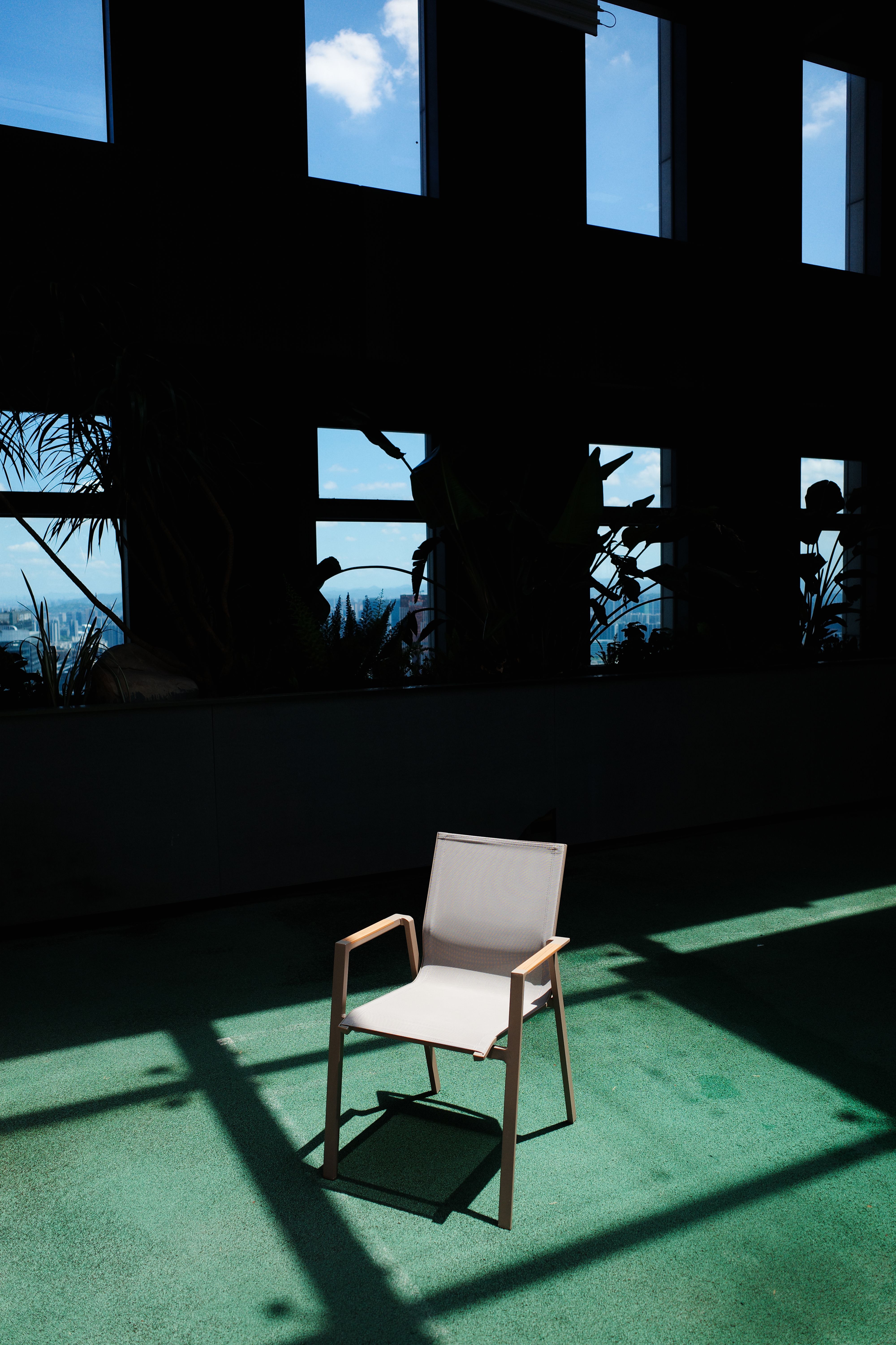 Single Chair in Dark Indoor Corridor with Windows · Free Stock Photo