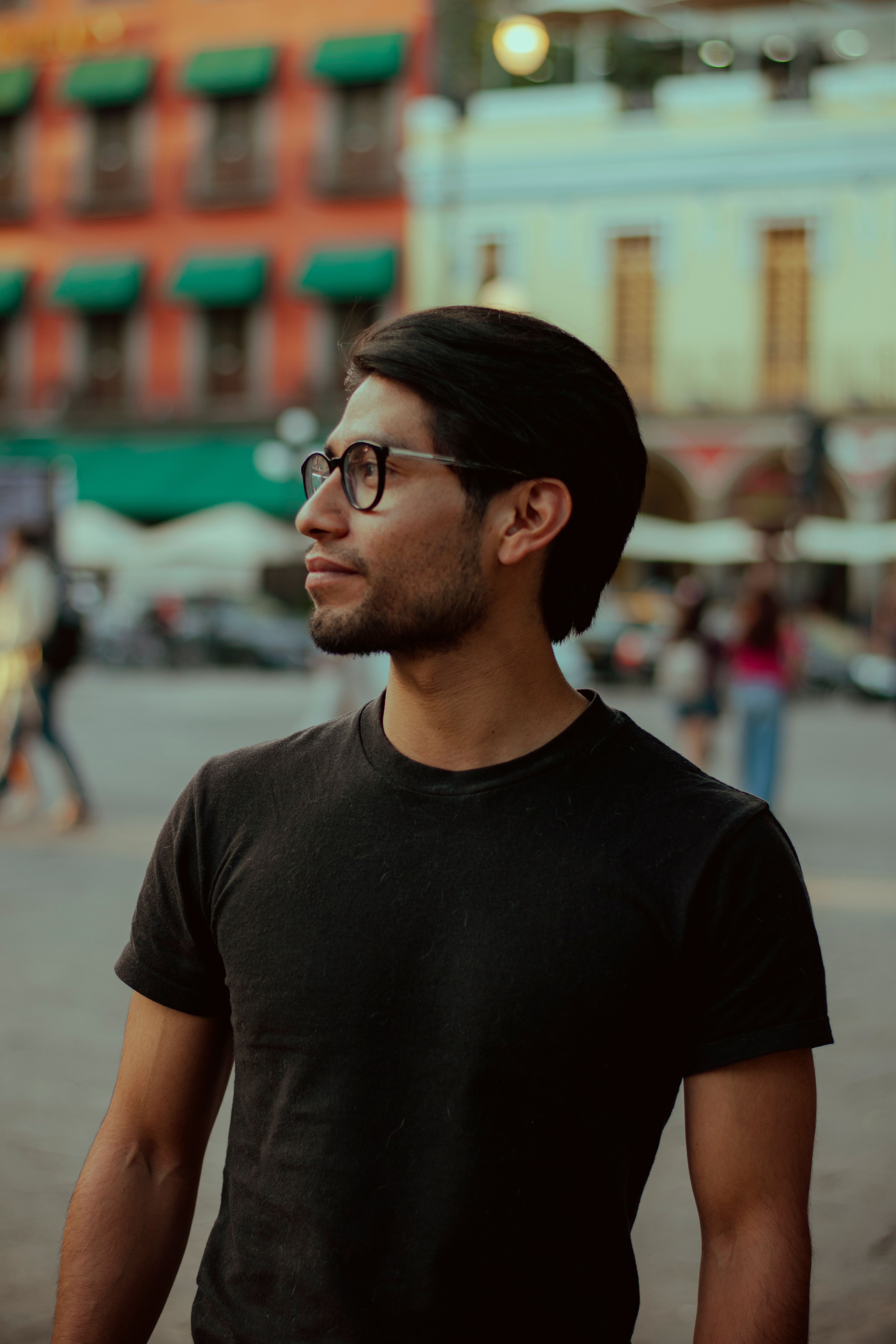 Young Man in Urban Square with Historic Buildings · Free Stock Photo