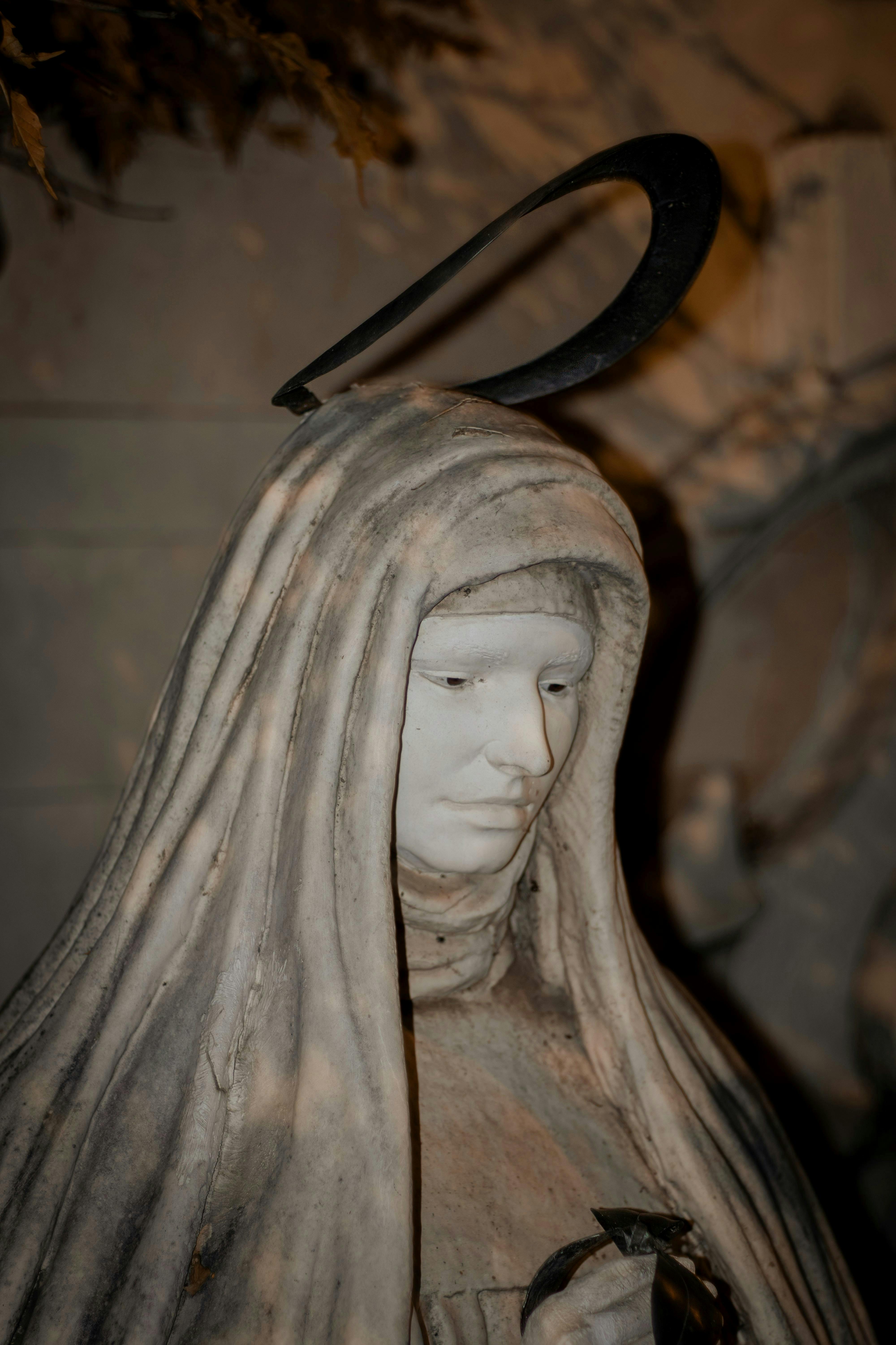 Stone Statue of a Saint with Halo in Dim Light · Free Stock Photo
