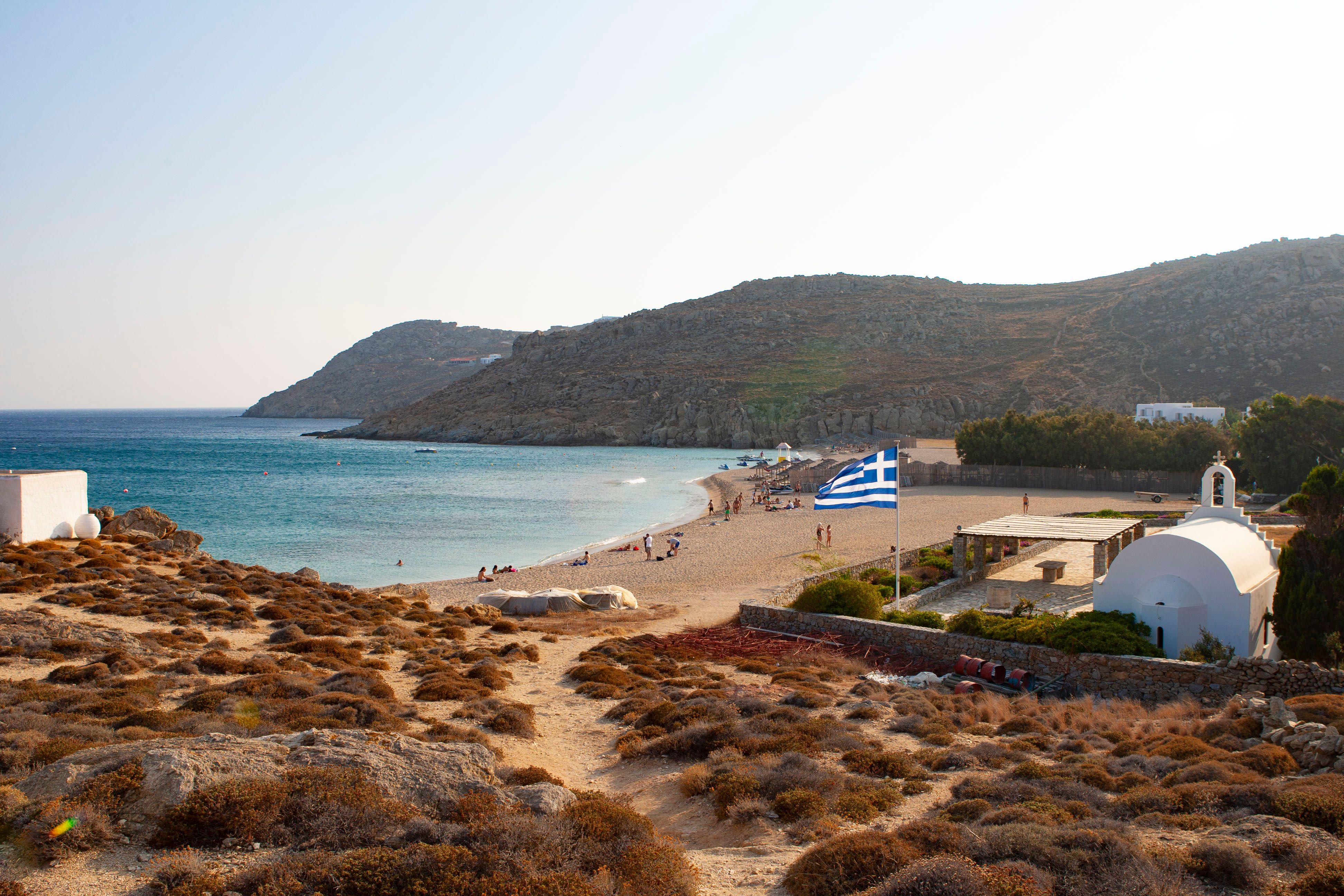 Greek Beach with Church and Flag in Mykonos · Free Stock Photo