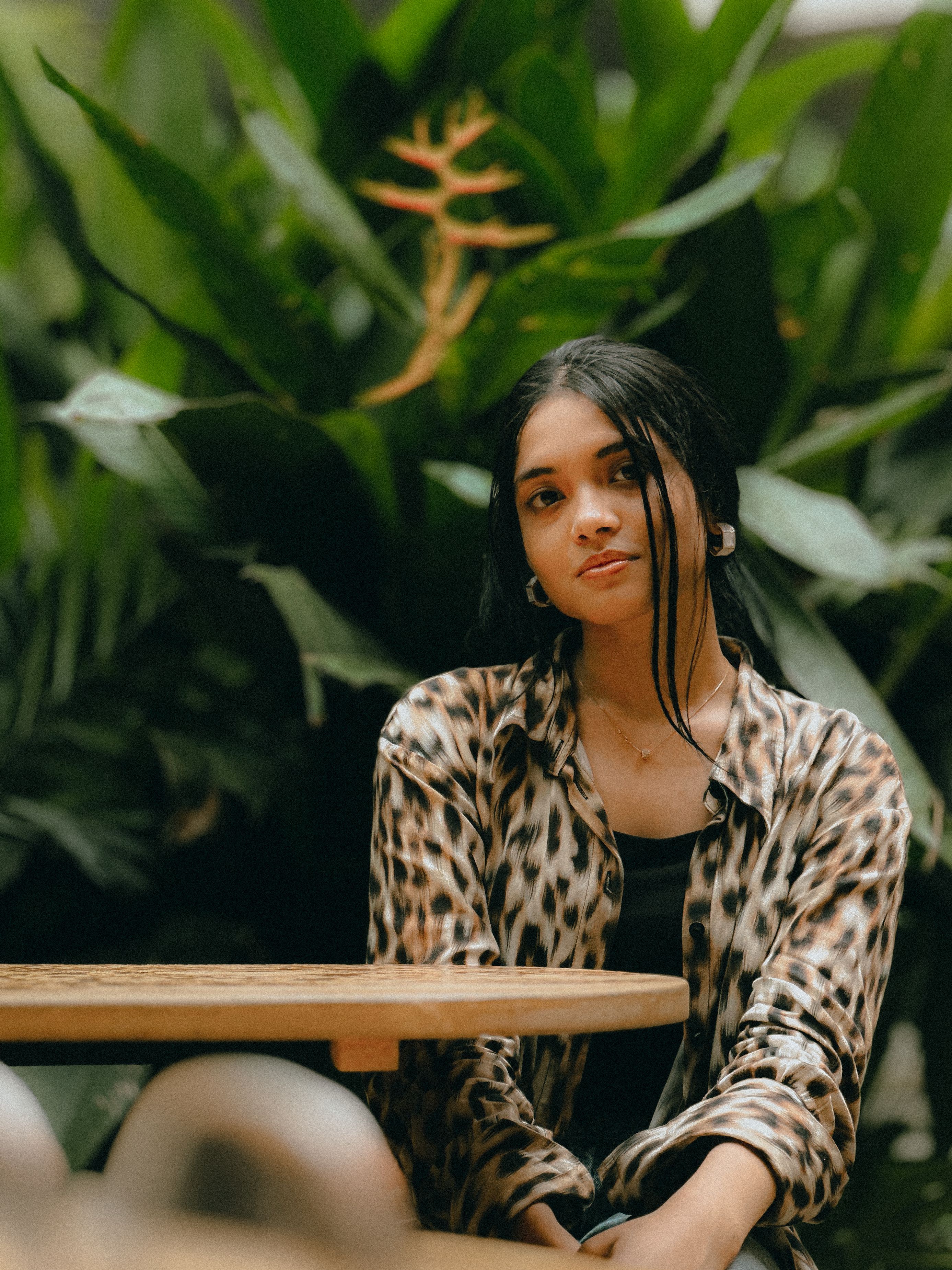 Stylish Woman in Leopard Print Amidst Lush Foliage · Free Stock Photo