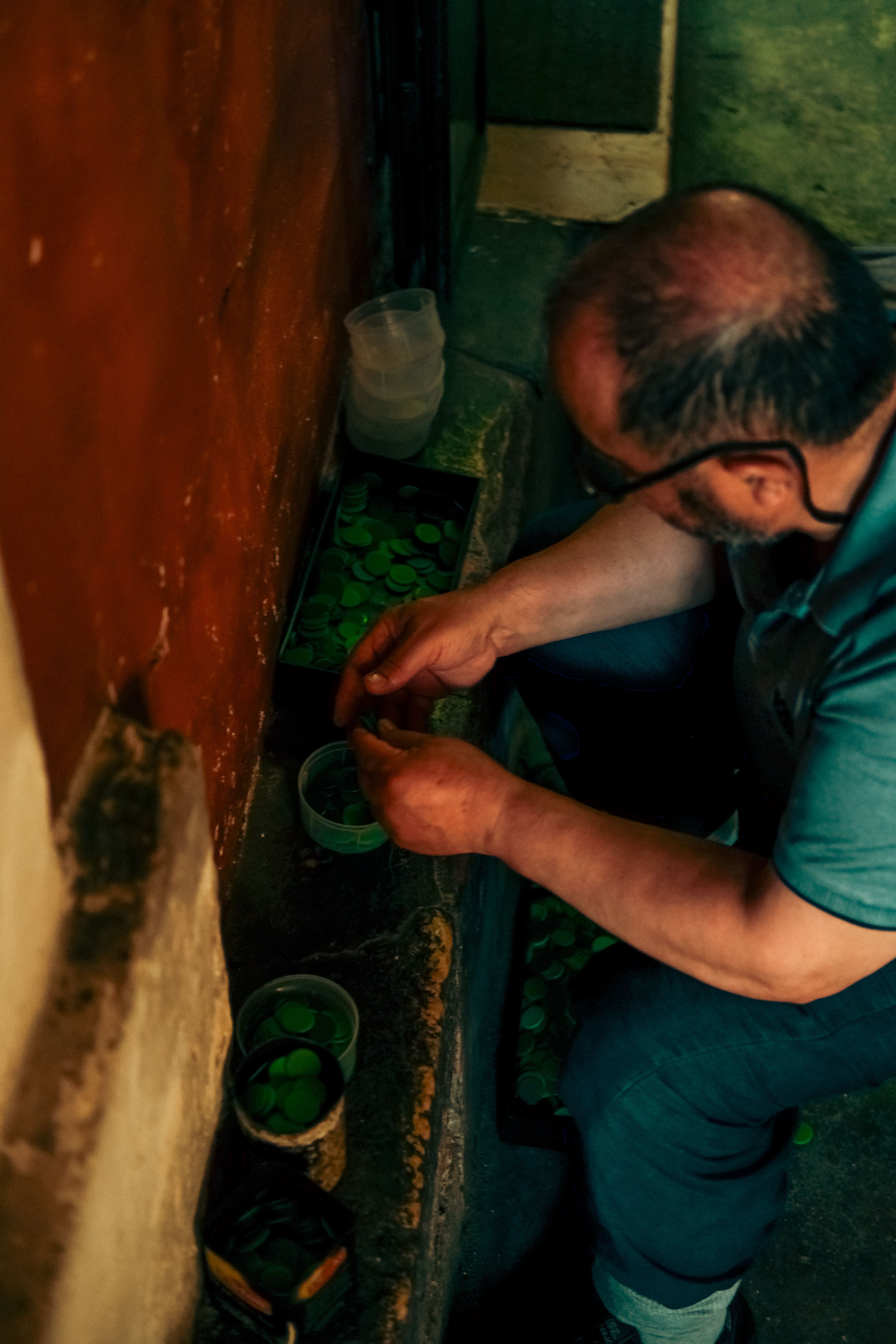 Man Preparing Green Leaves in Dim Lighting · Free Stock Photo