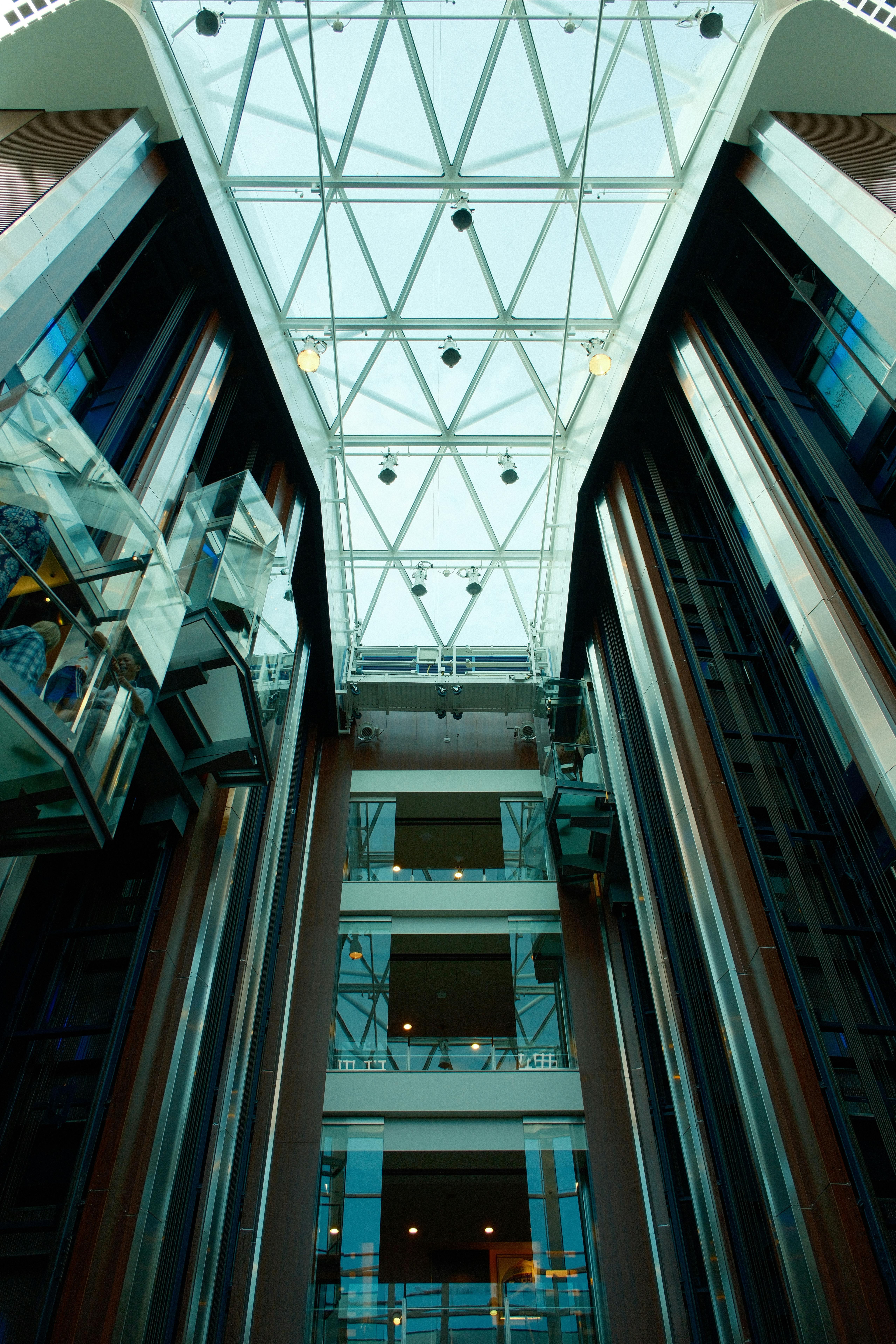 Modern Glass Atrium with Elevators and Skylight · Free Stock Photo