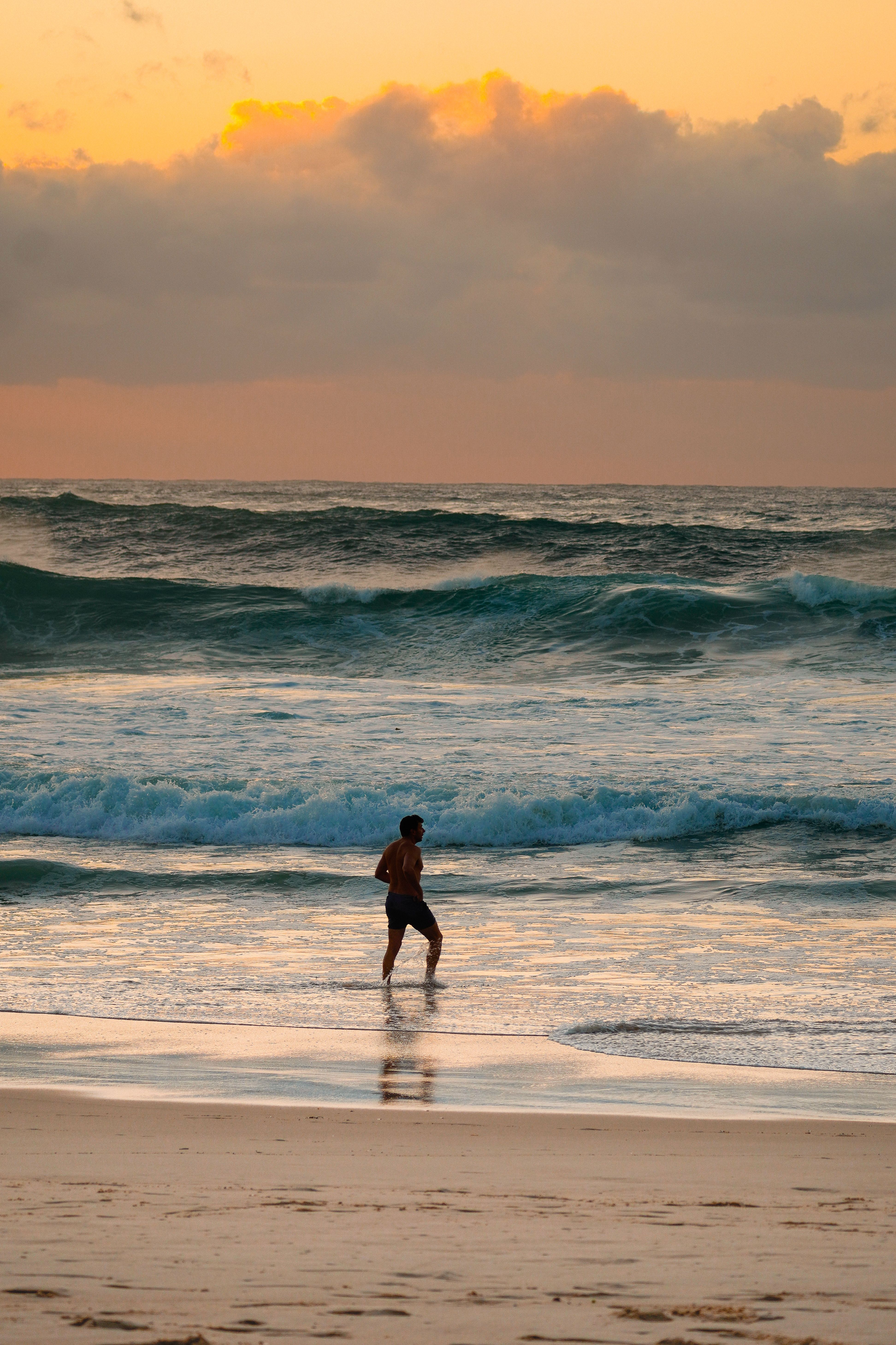 Man Walking on Beach at Sunrise with Waves · Free Stock Photo