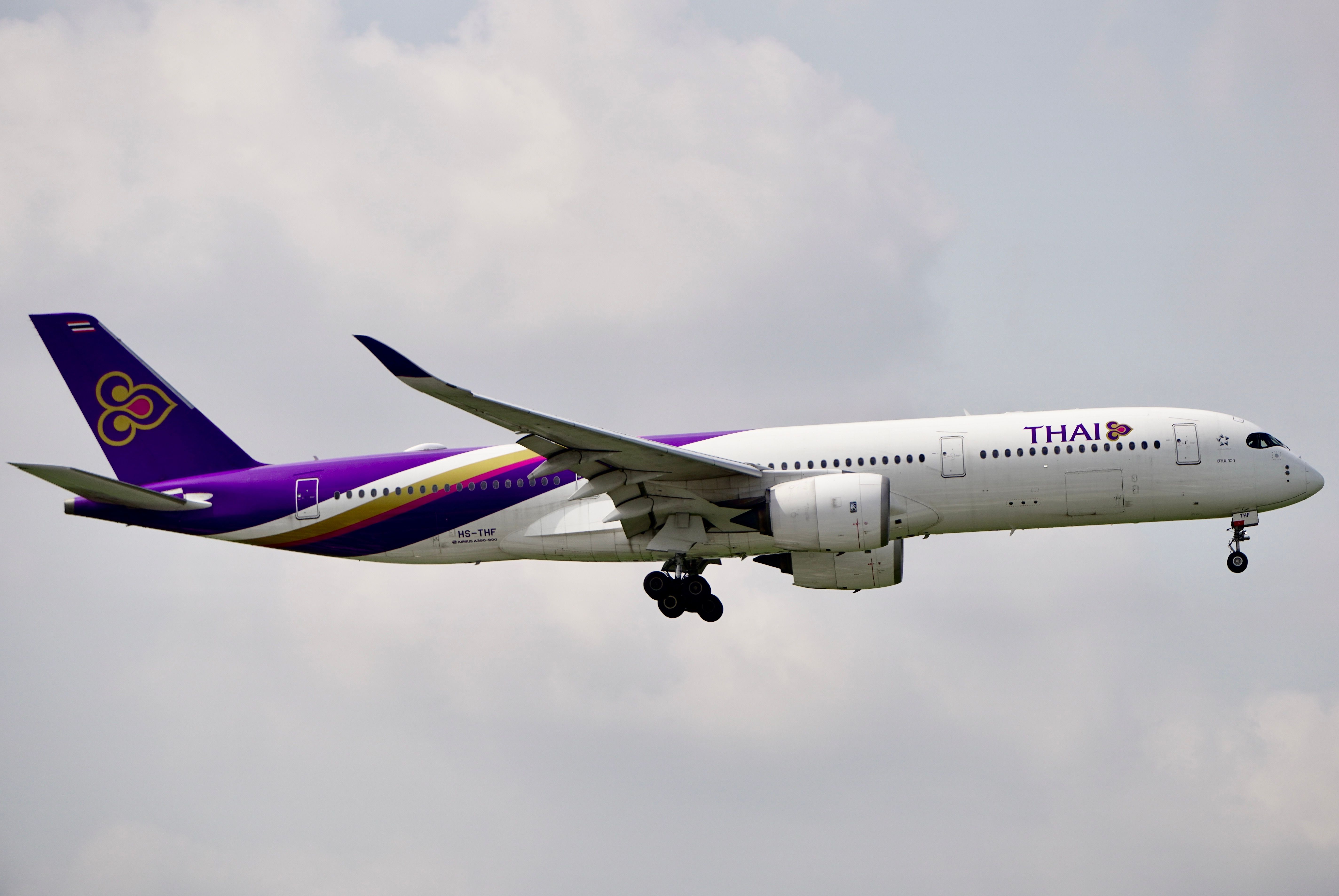 Thai Airways Plane in Flight Against Cloudy Sky · Free Stock Photo
