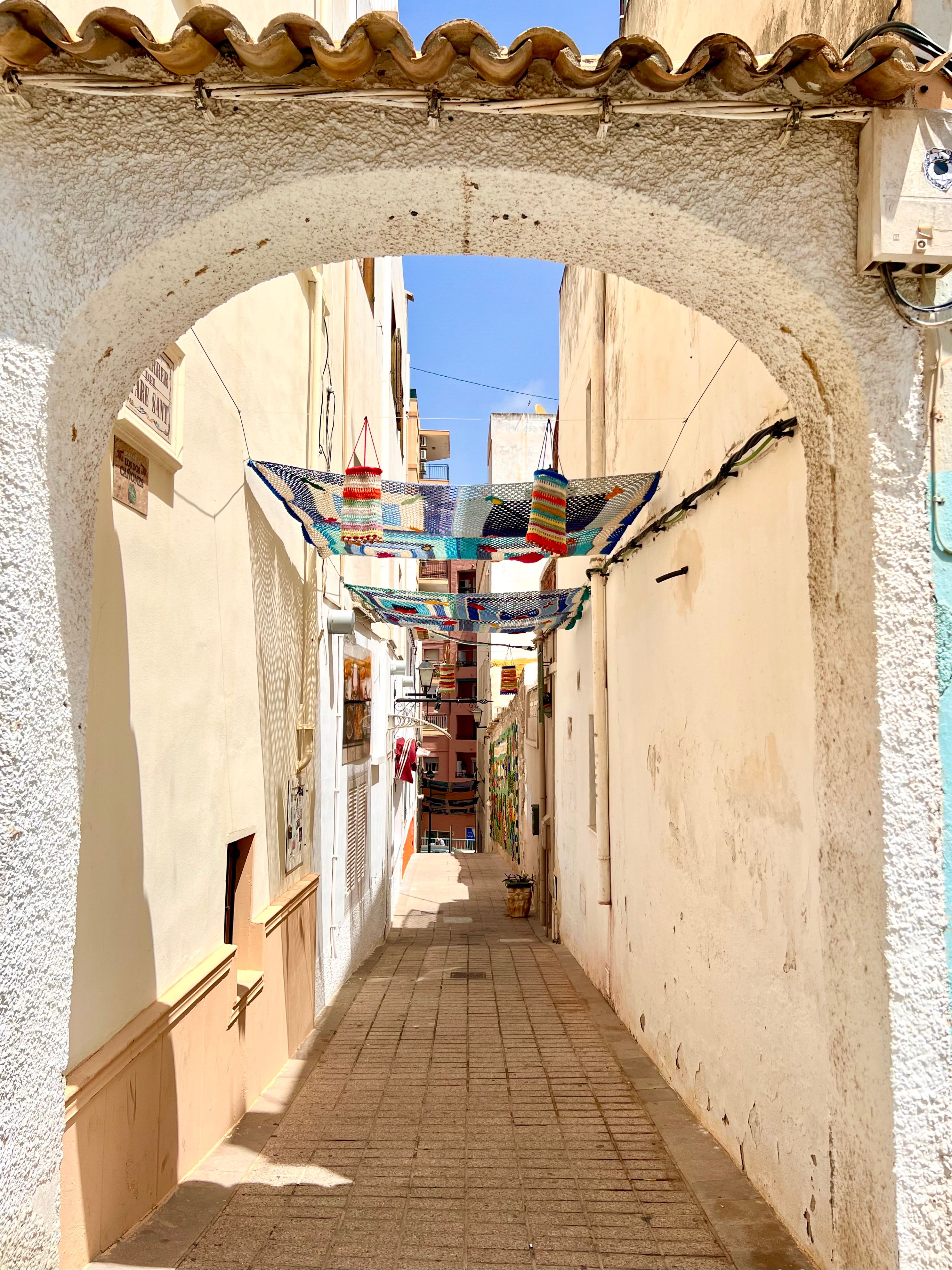 Charming Spanish Alleyway with Colorful Textiles · Free Stock Photo