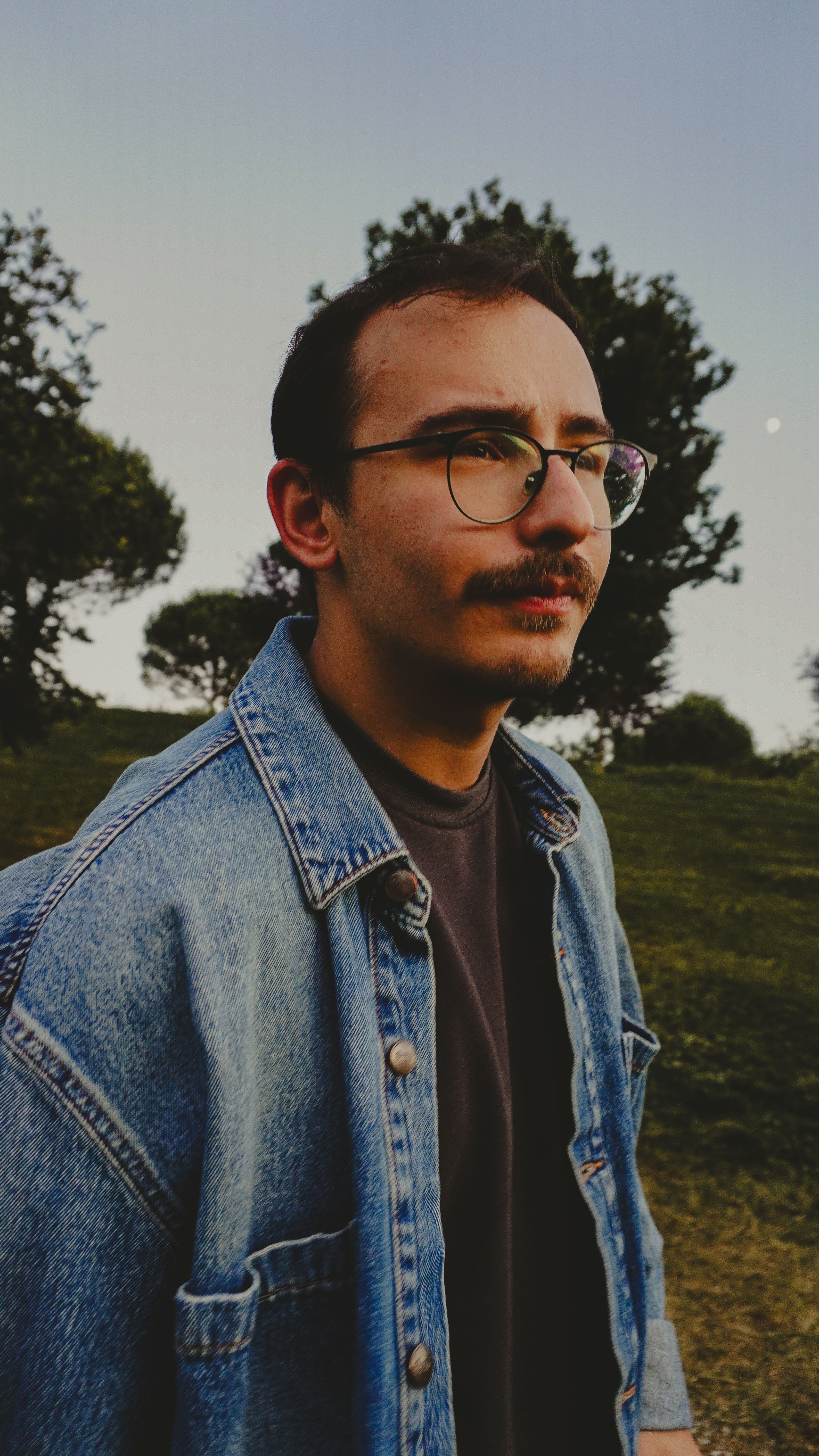 Profile of Man in Denim Jacket Outdoors · Free Stock Photo