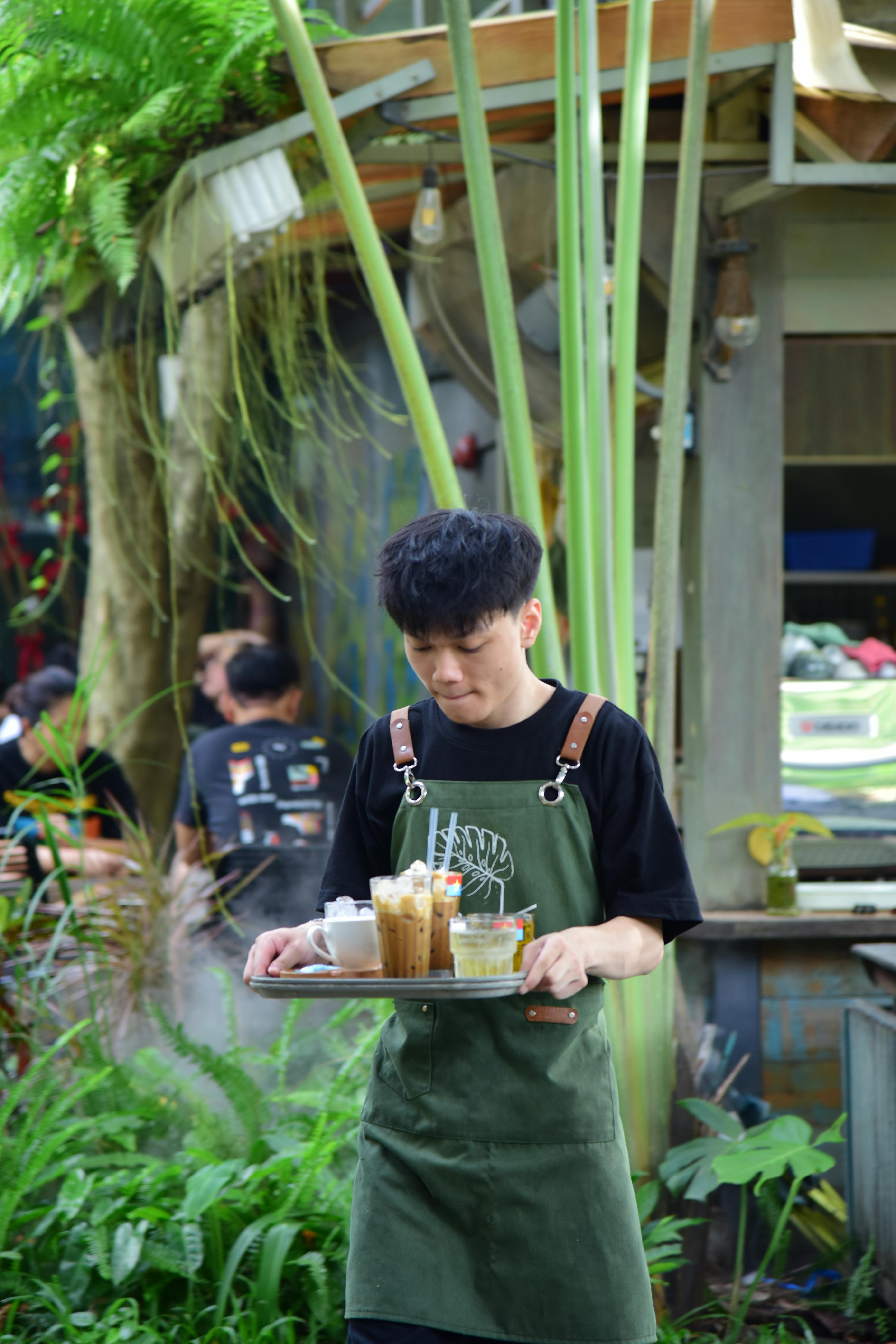 Young Barista Serving Drinks in Outdoor Café · Free Stock Photo