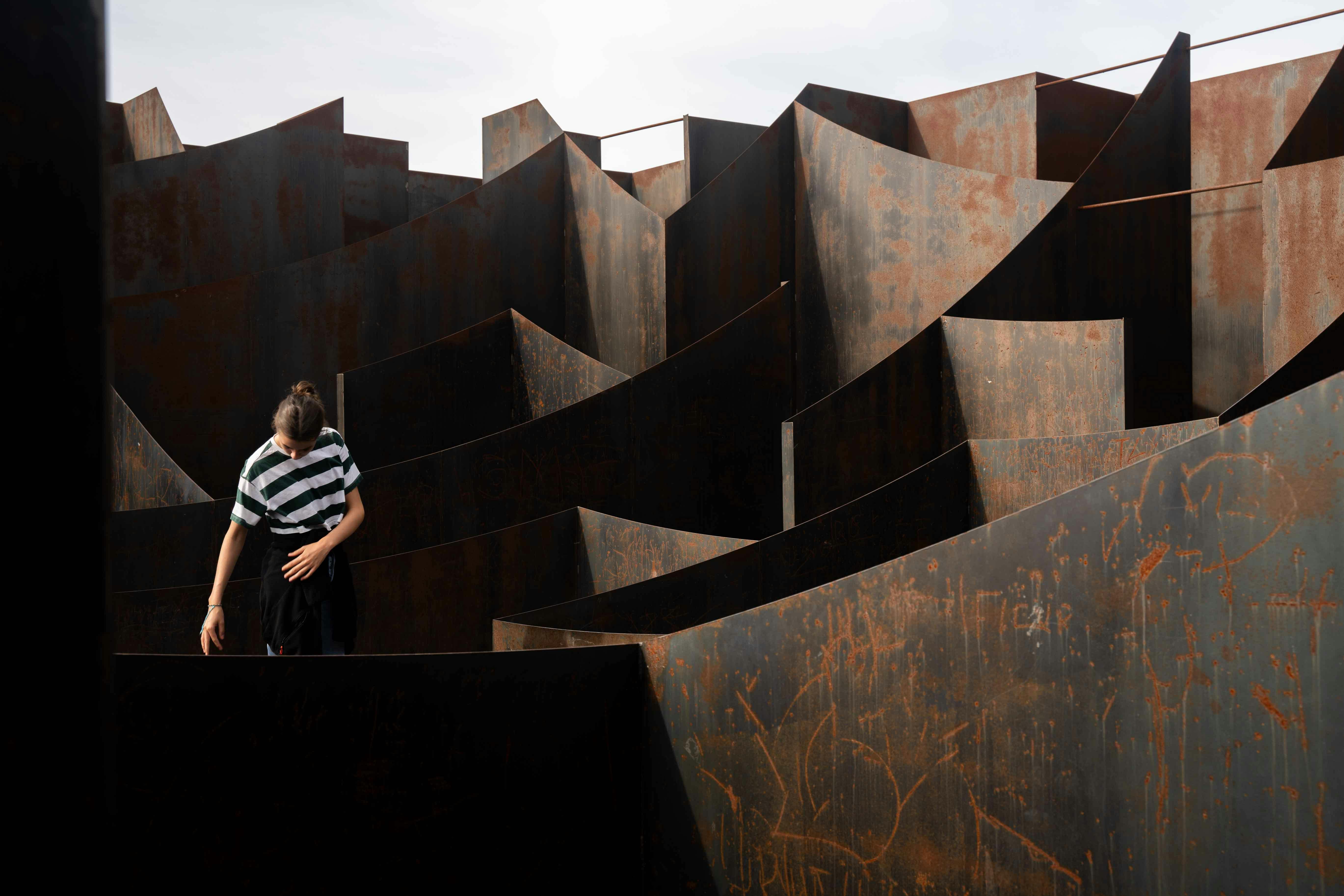 Contemplative Moment in Modern Rusted Maze Sculpture · Free Stock Photo