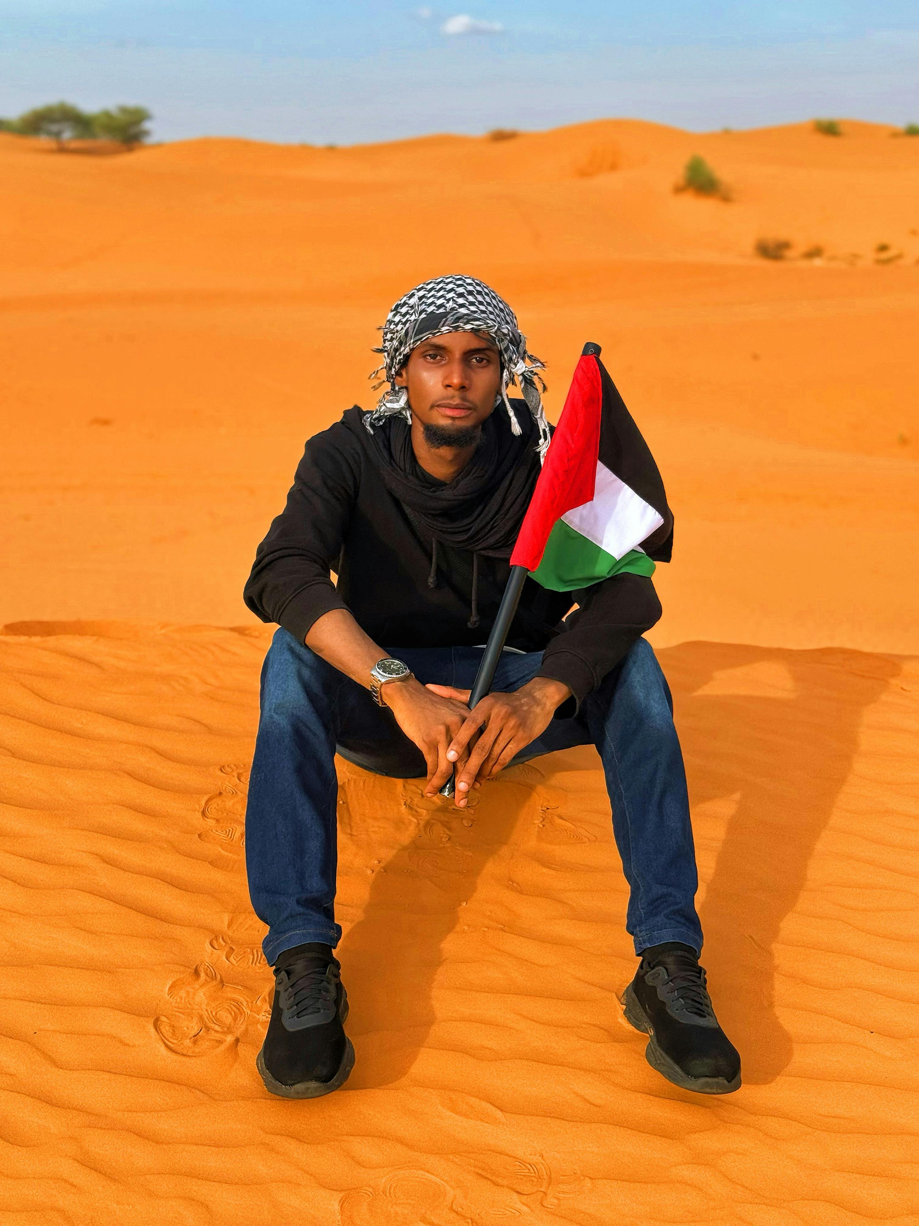 Man in Diffa Desert Holding Palestinian Flag · Free Stock Photo