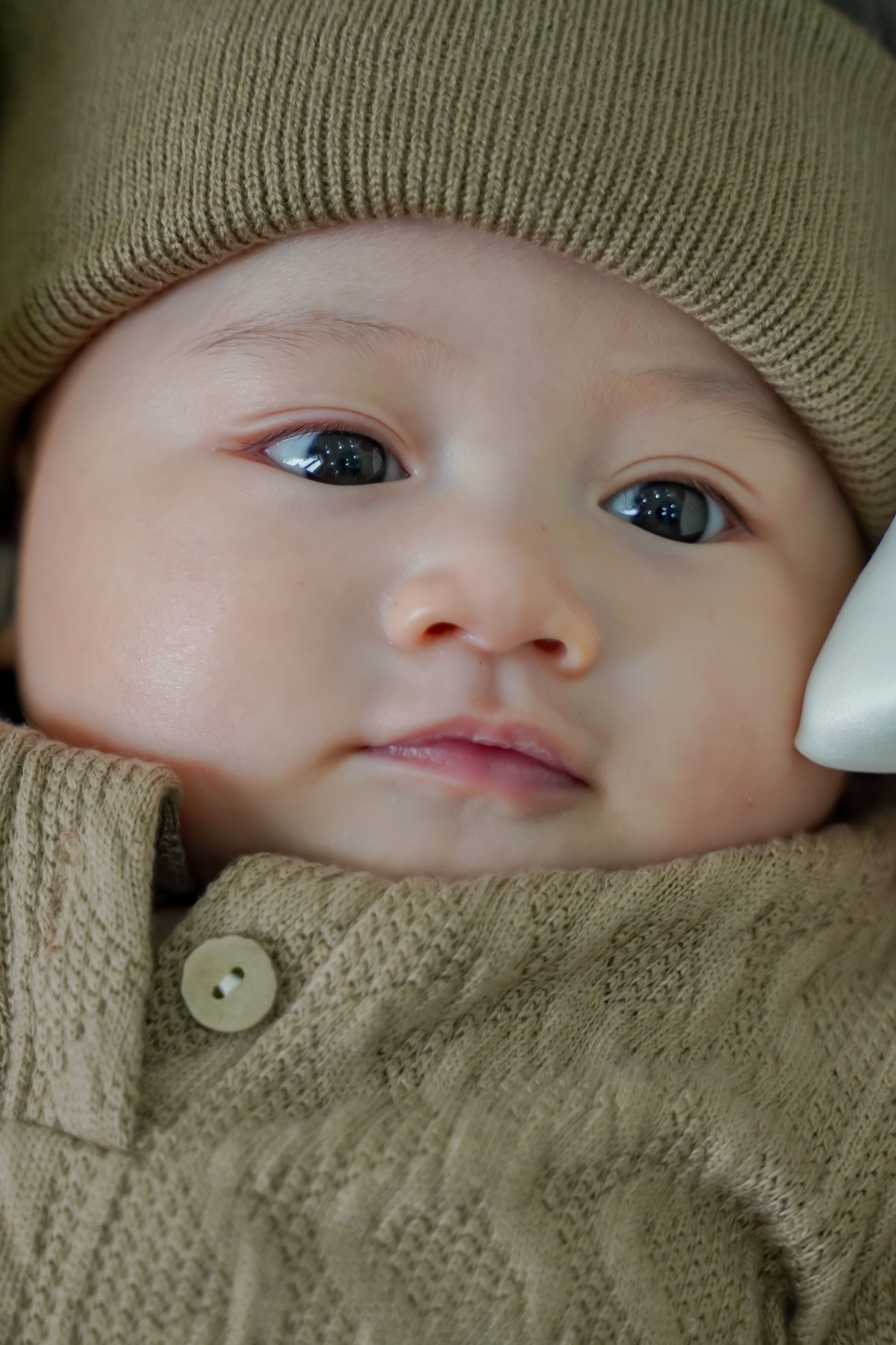 Close-up Portrait of a Baby in Beige Outfit · Free Stock Photo