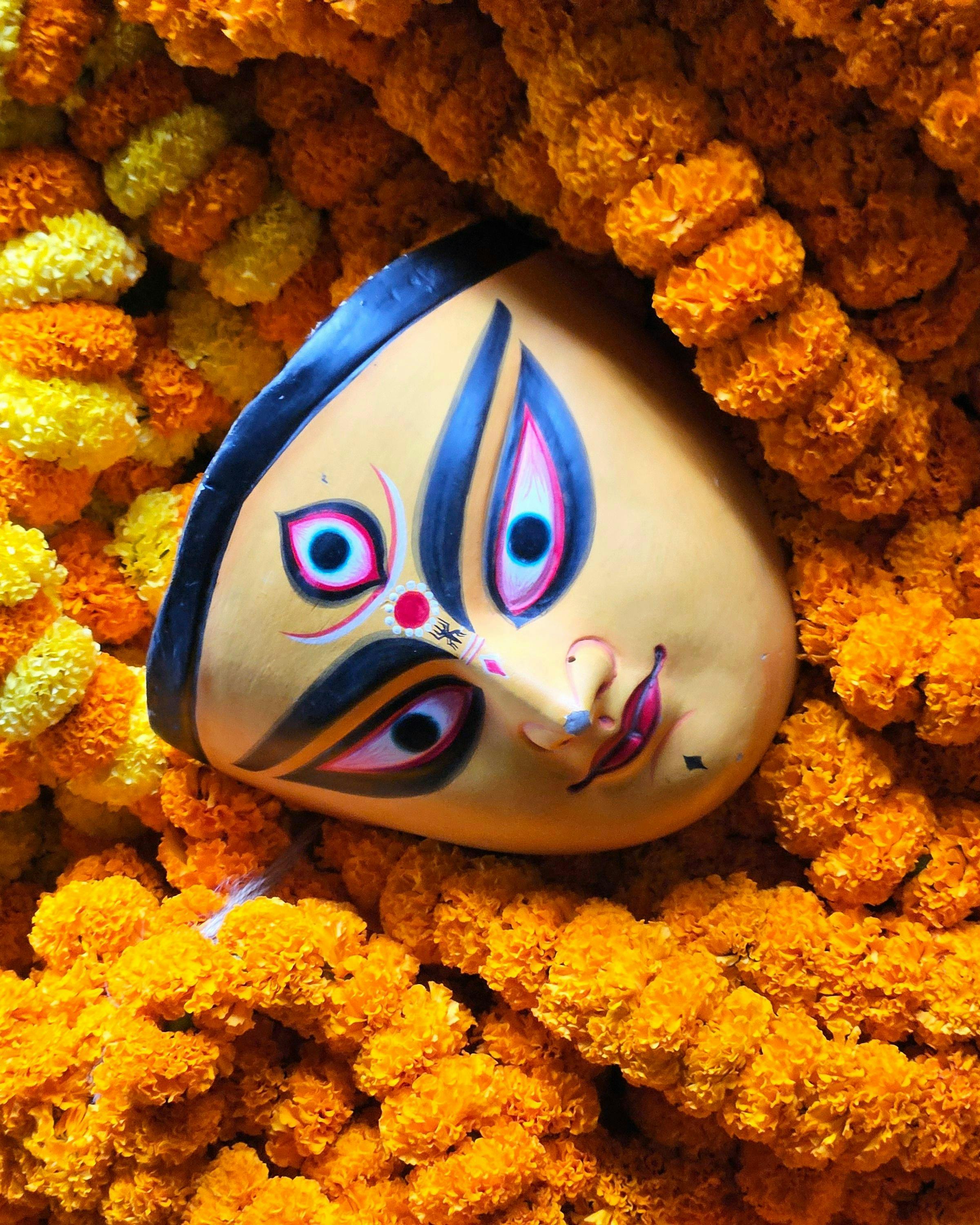 Colorful Durga Mask Surrounded by Marigold Garlands · Free Stock Photo