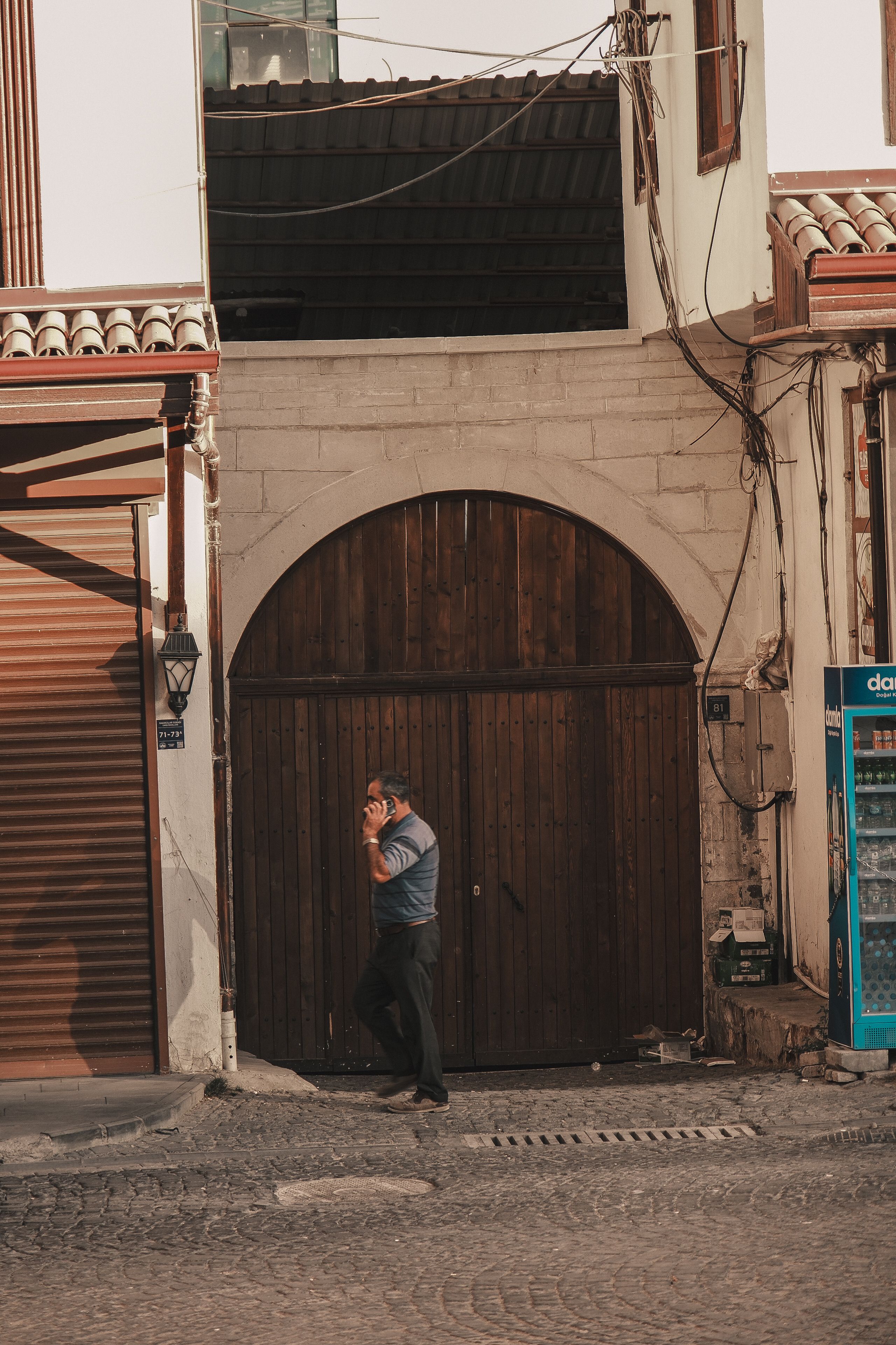 Urban Street Scene with Man Walking by Old Building · Free Stock Photo