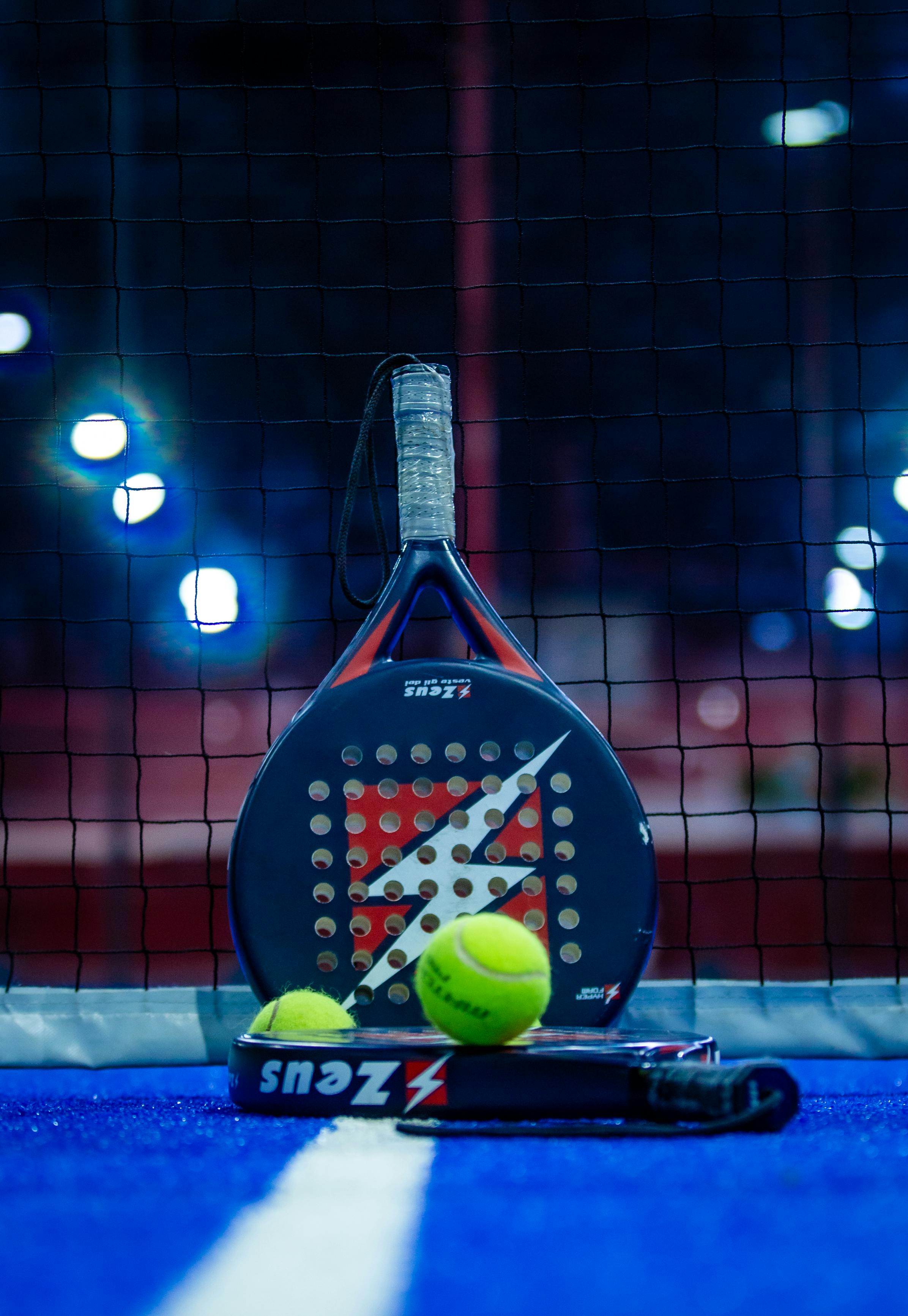Dynamic Padel Racket and Ball on Blue Court · Free Stock Photo
