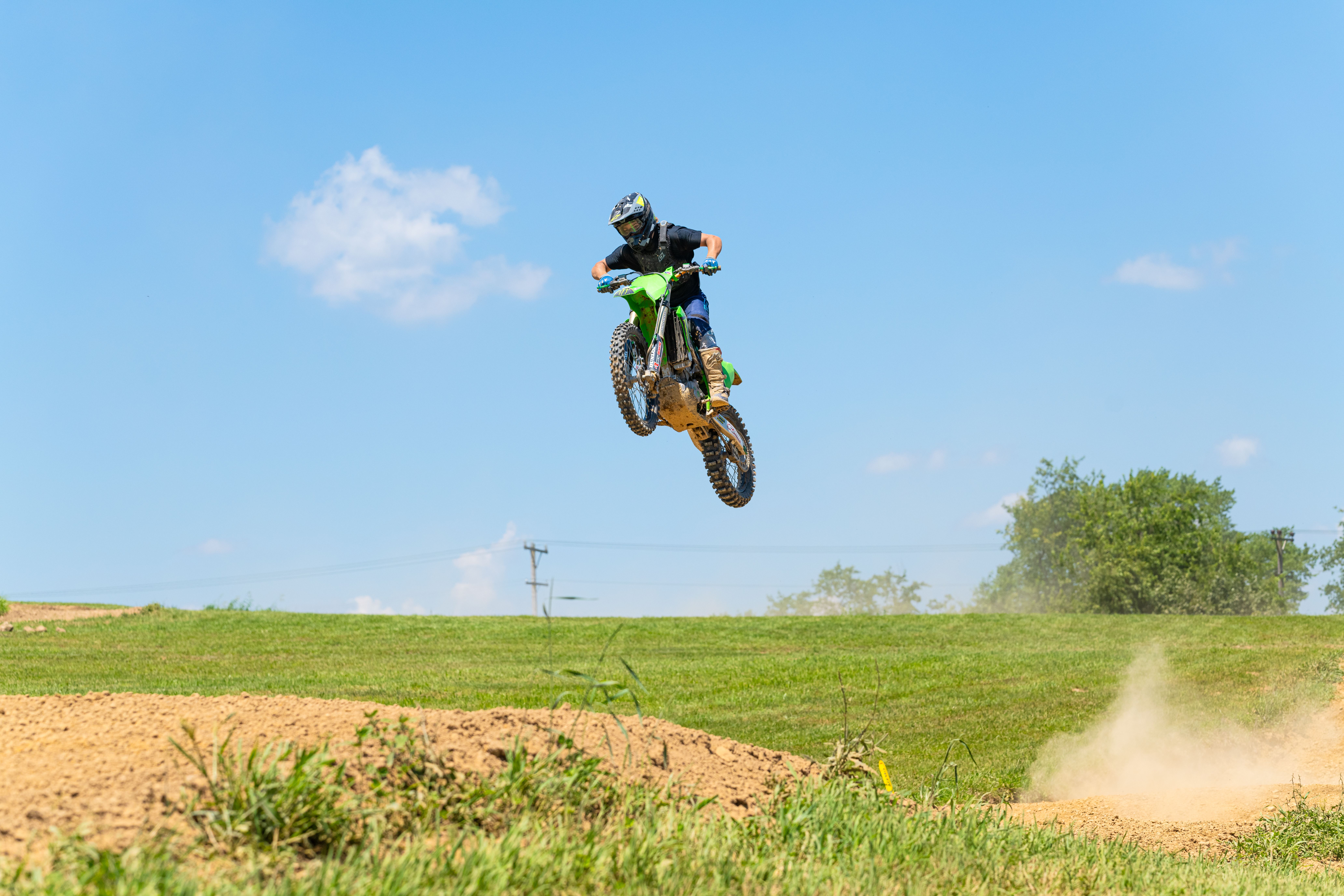 High-Flying Motocross Jump in Sunny Field · Free Stock Photo