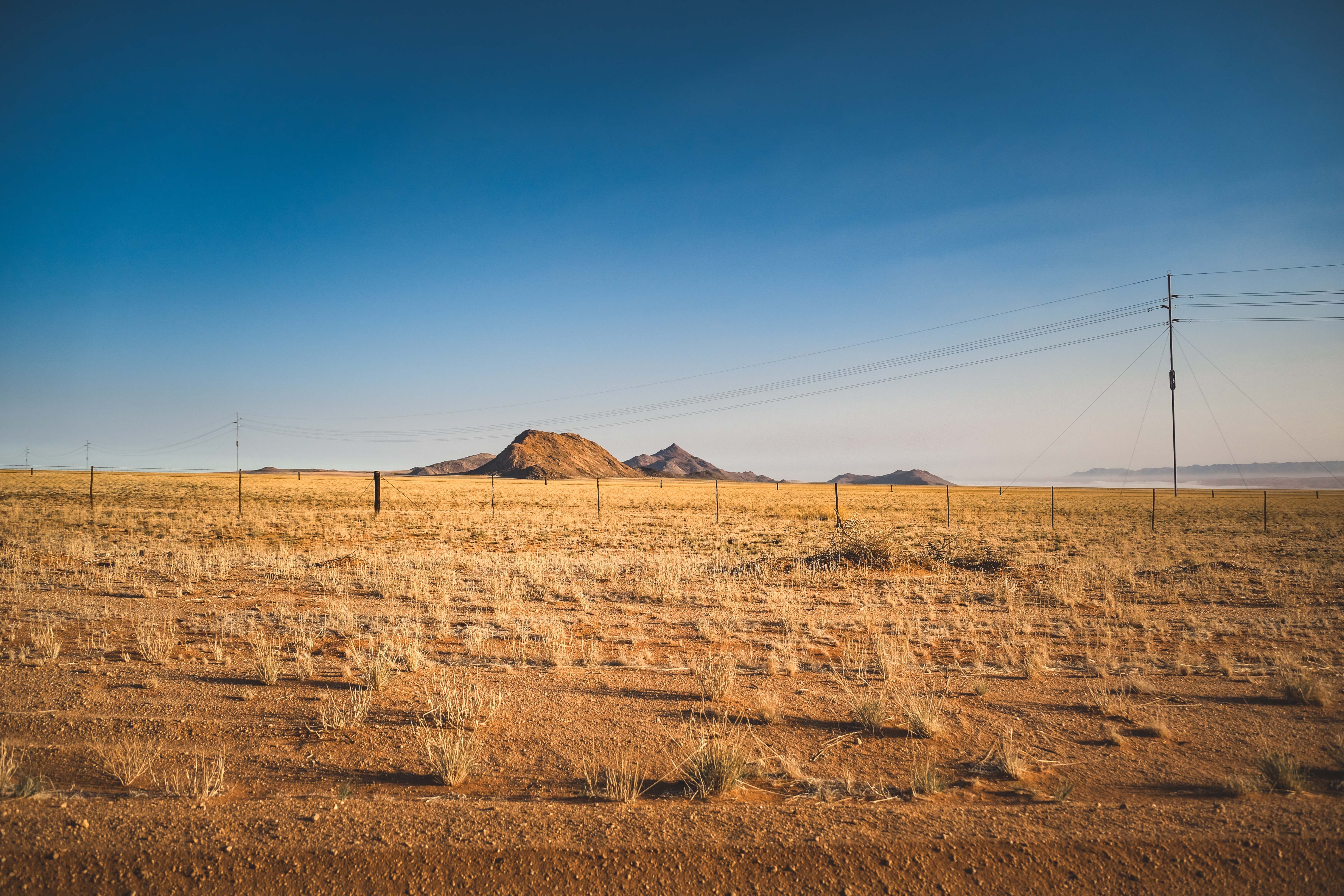 Sunny Desert Landscape with Distant Hills · Free Stock Photo